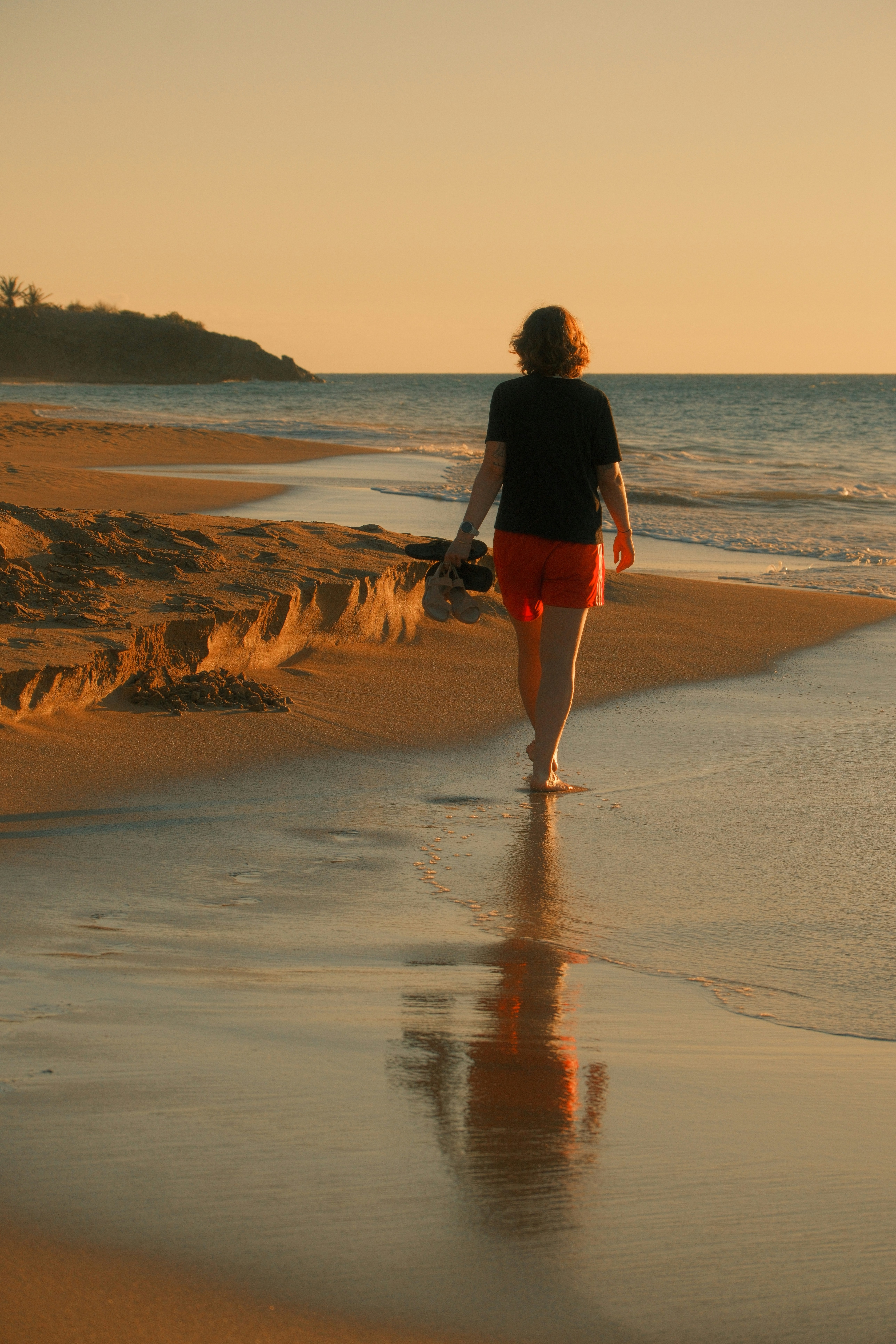 Golden Hour Stroll: Silhouette of a Wanderer on Quiet Shore