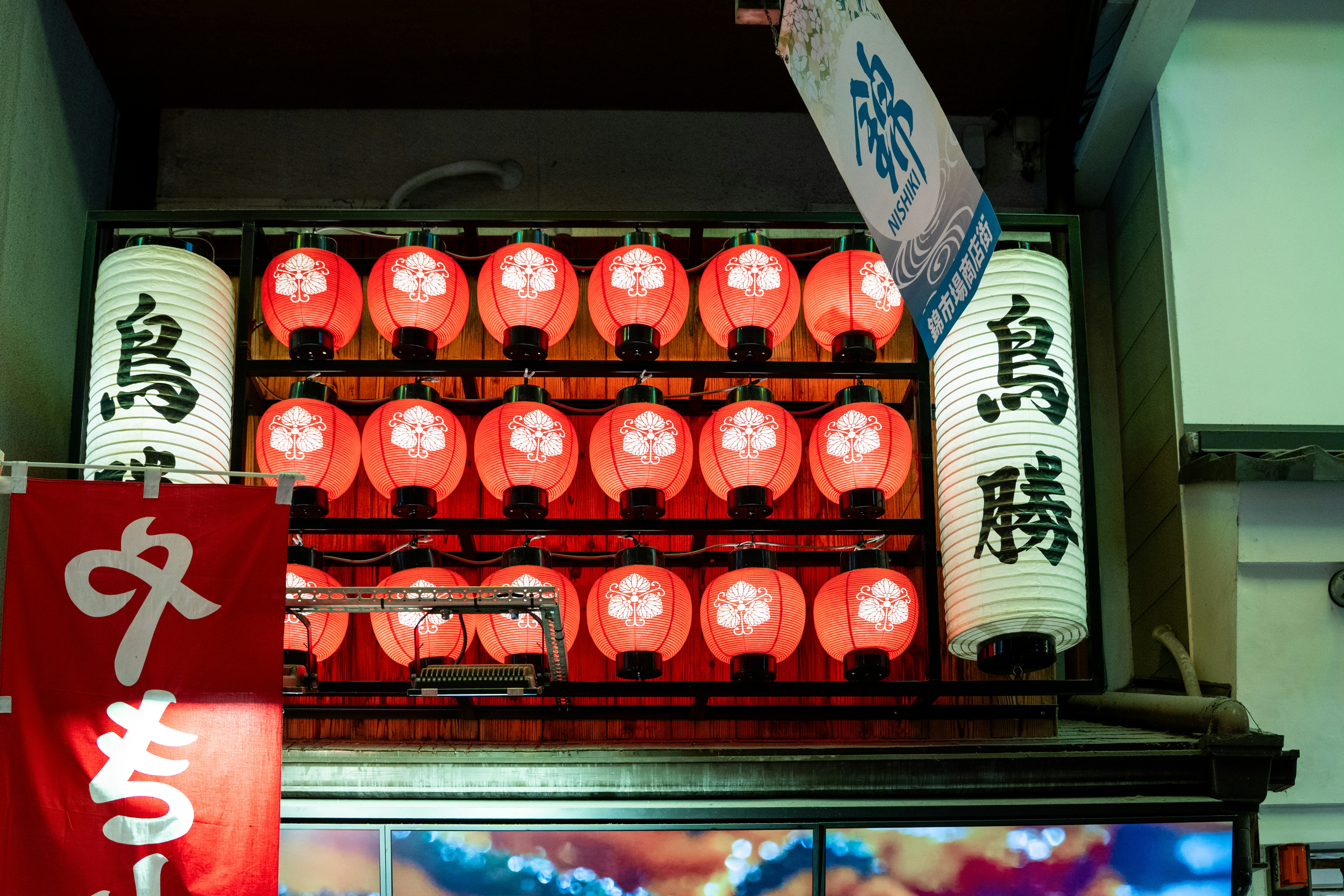 Row of red lanterns under a neon-lit storefront