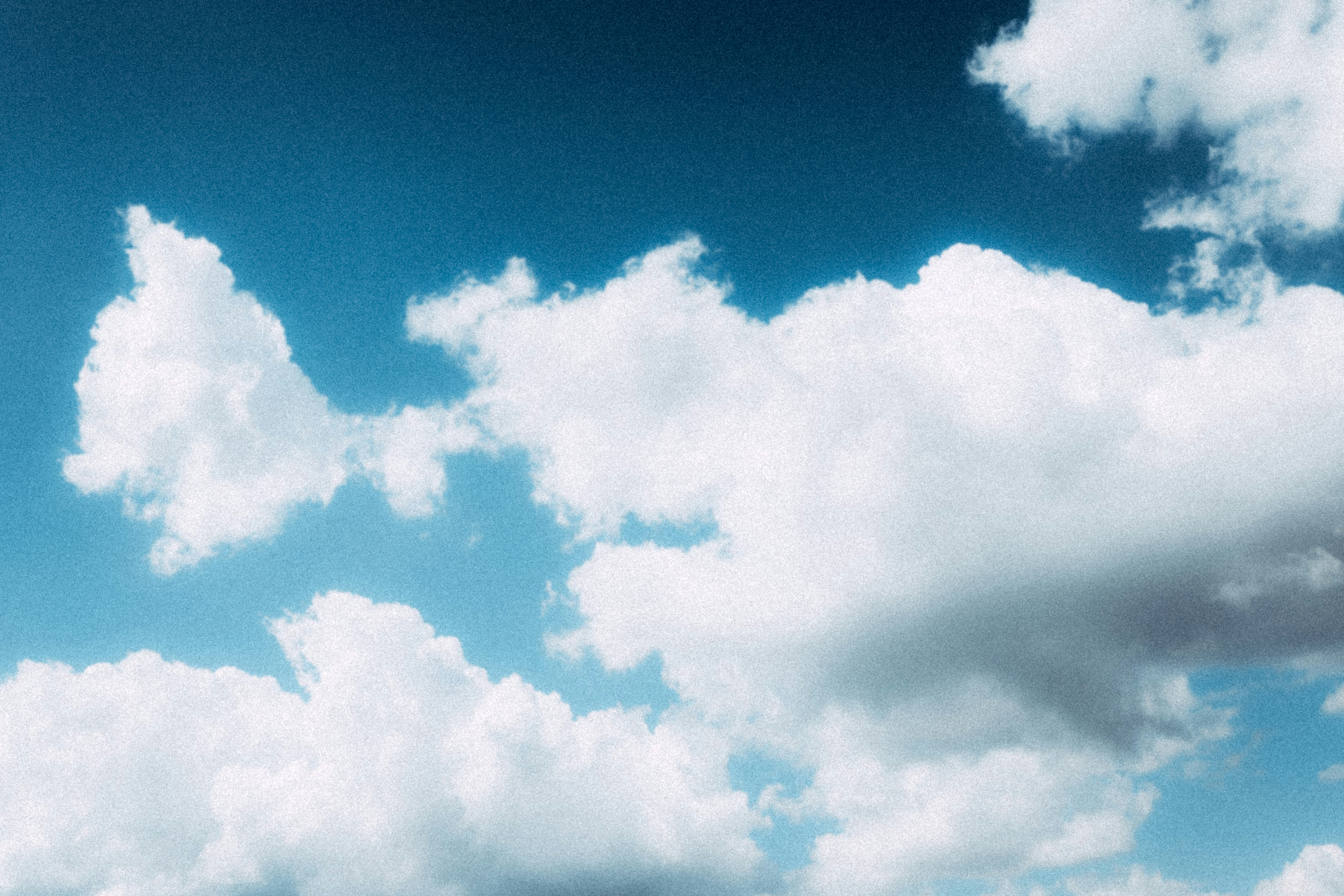Azure Sky Canvas: Puffy Clouds Across a Bright Noon