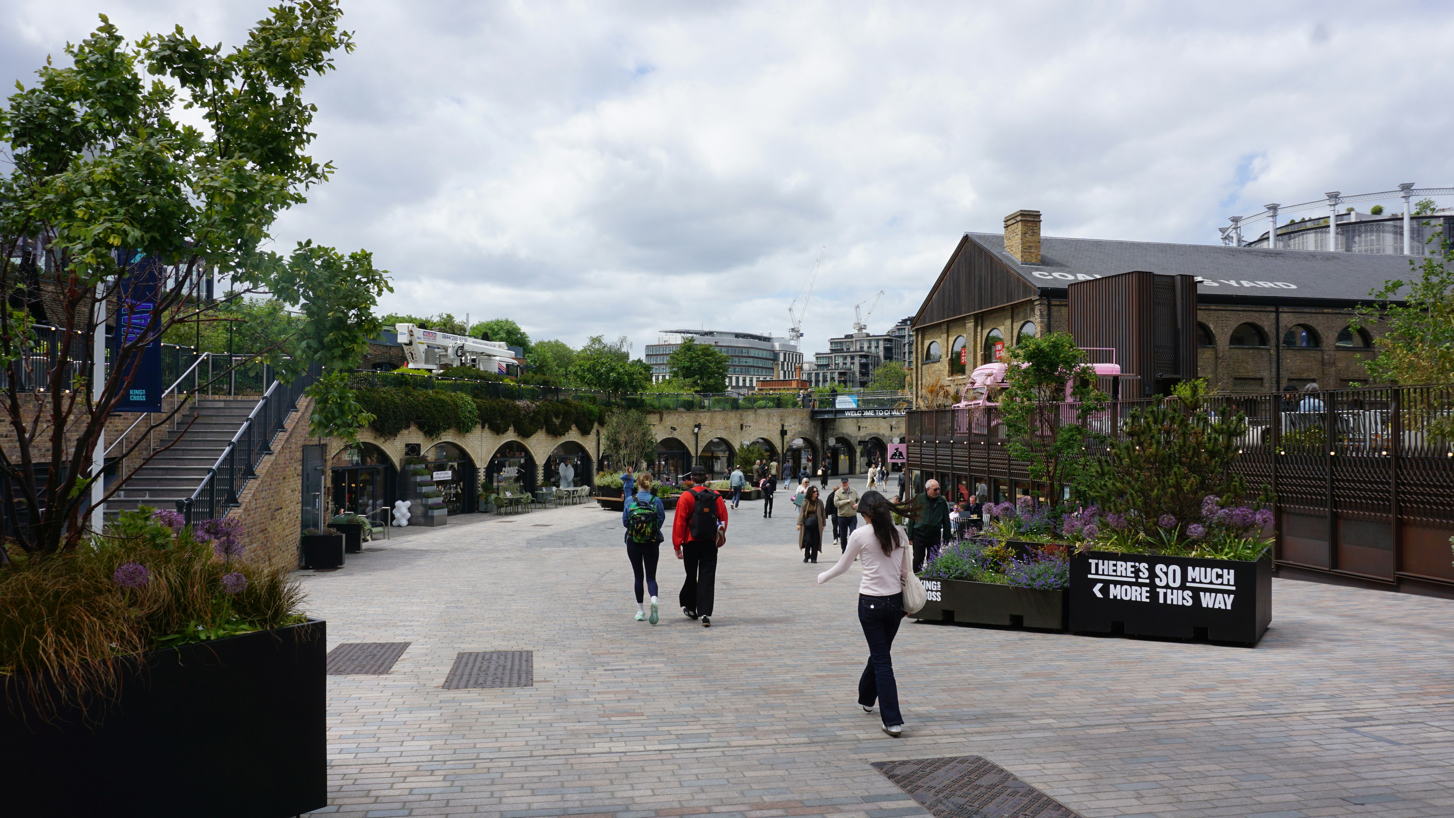 Transit of People Through a Courtyard Under Arched Walkways