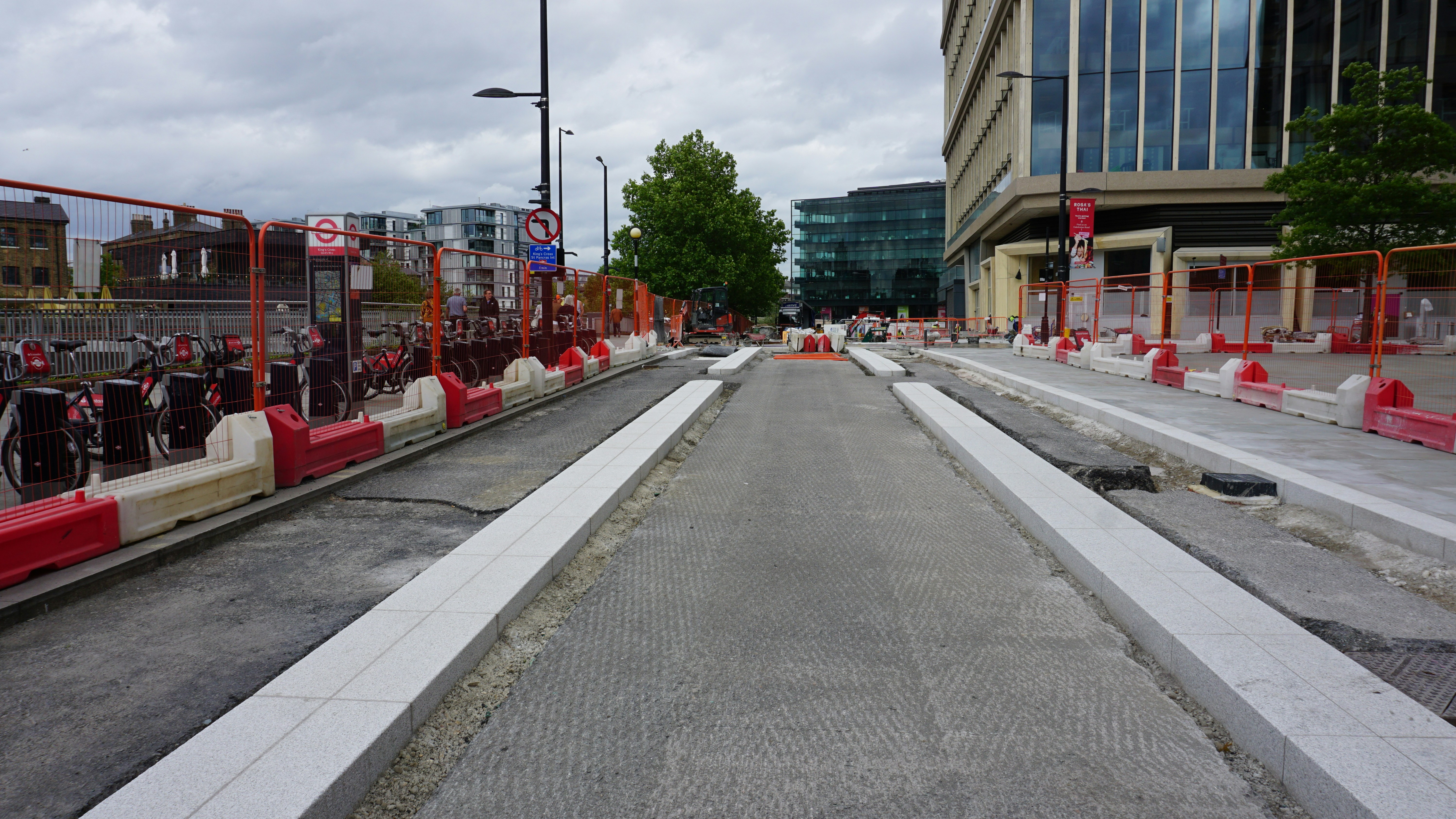 Construction Corridor: Red Barriers Recede into a City Road
