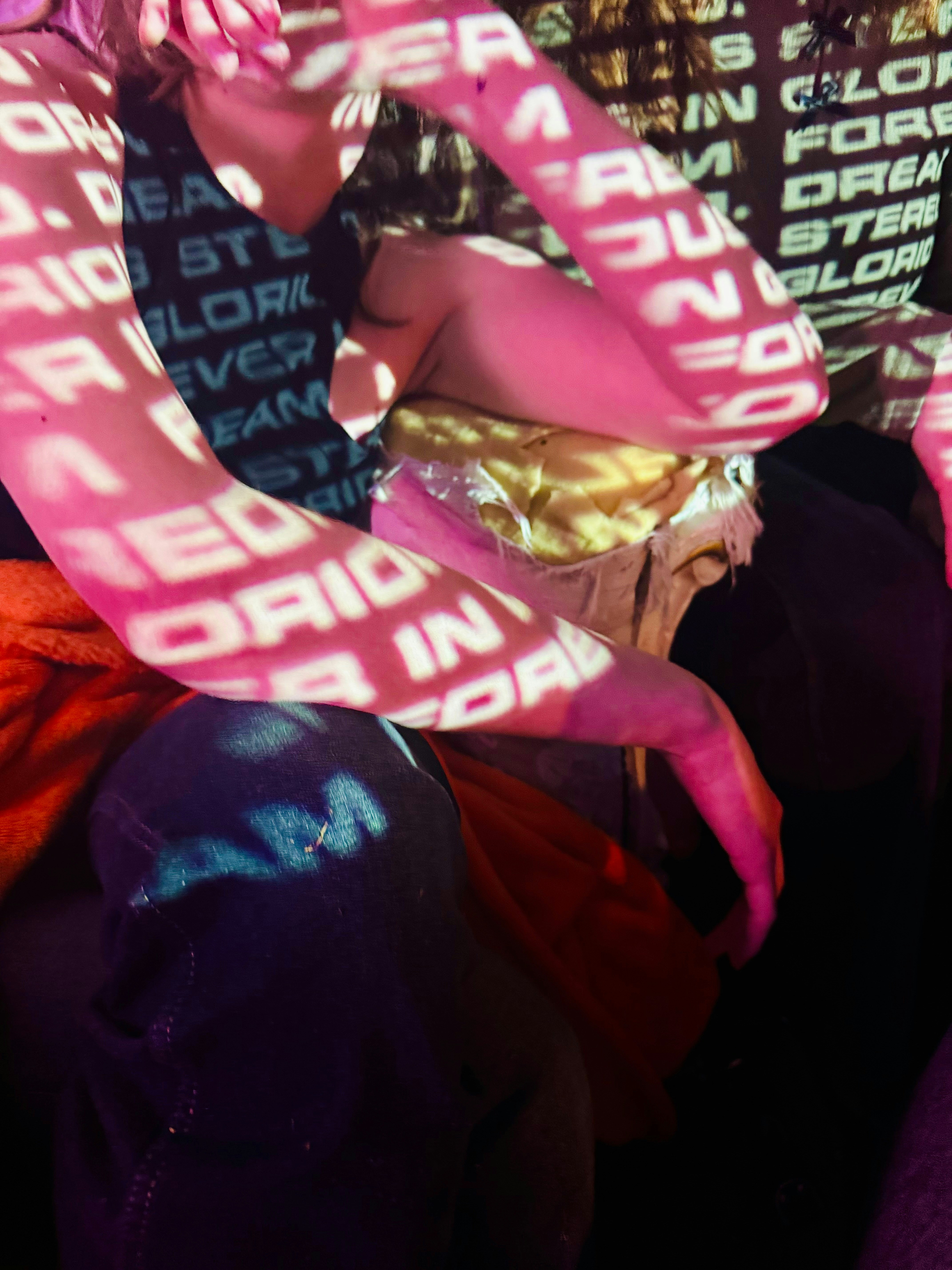 Red text projected onto a person's arms and body.