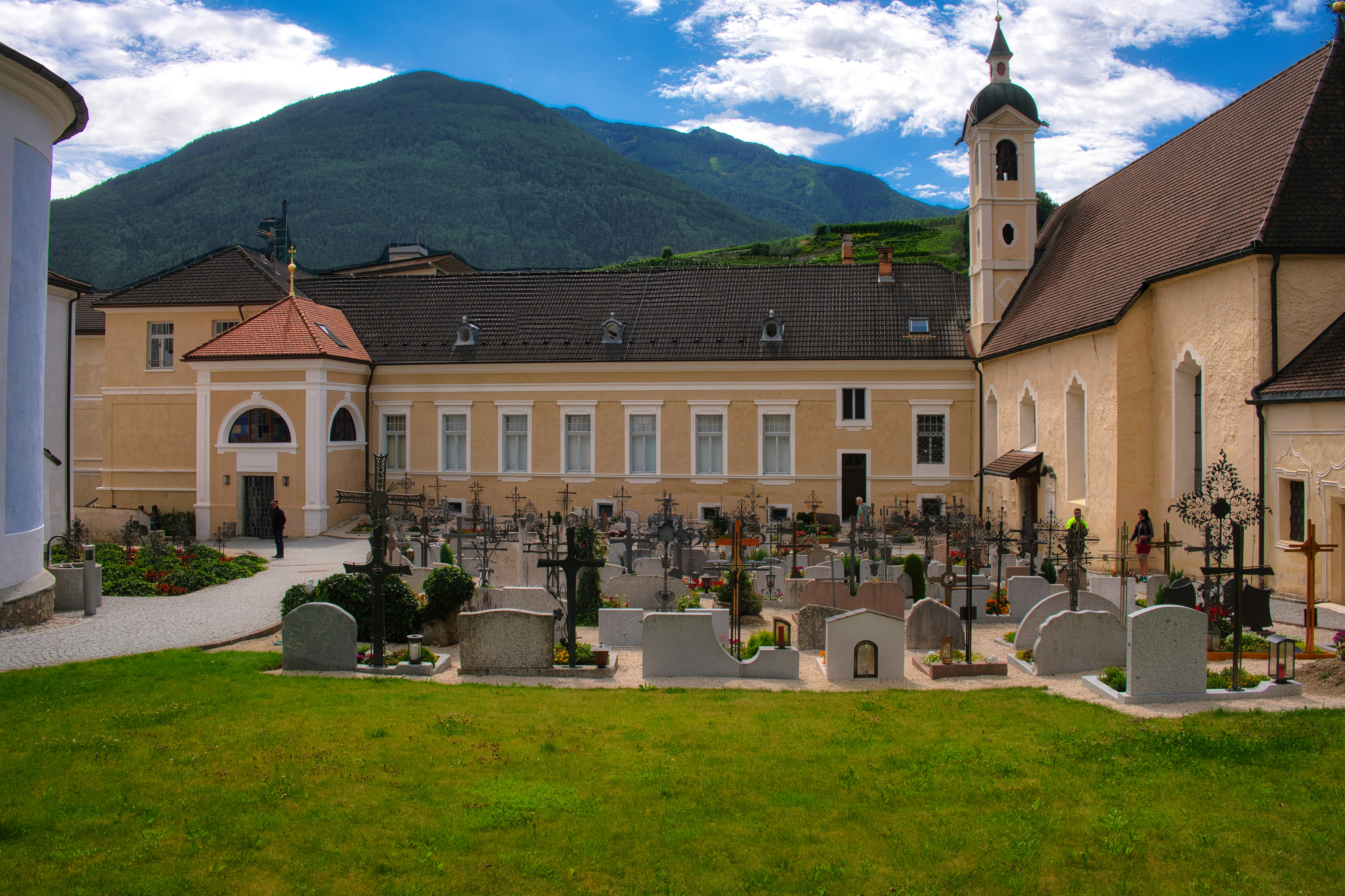 Court of the Quiet Abbey: a sunlit graveyard between pastel cloisters