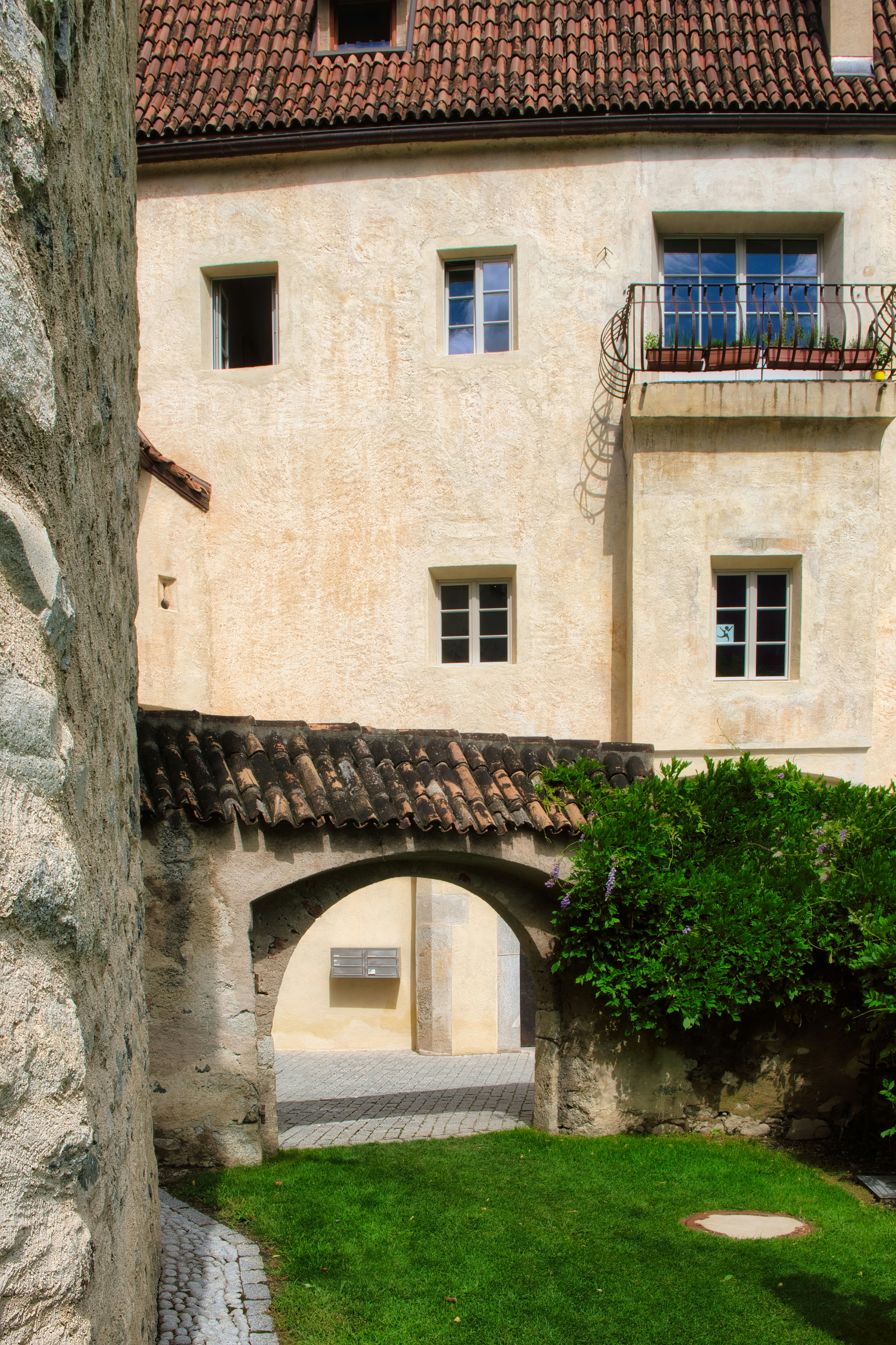Arched Passageway Beneath a Sunlit Facade