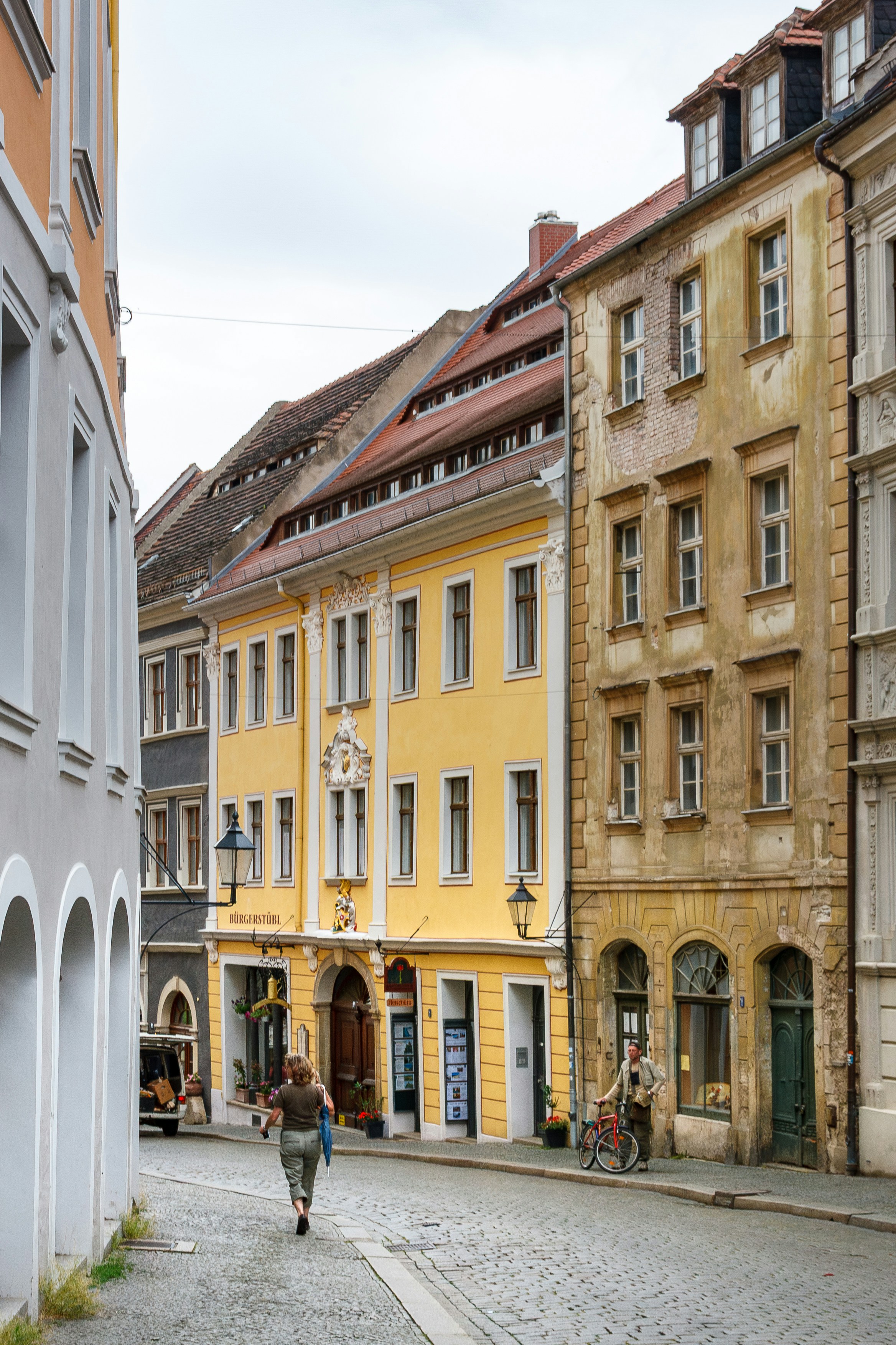 Cobbled Street in Sunlit Pastel Row