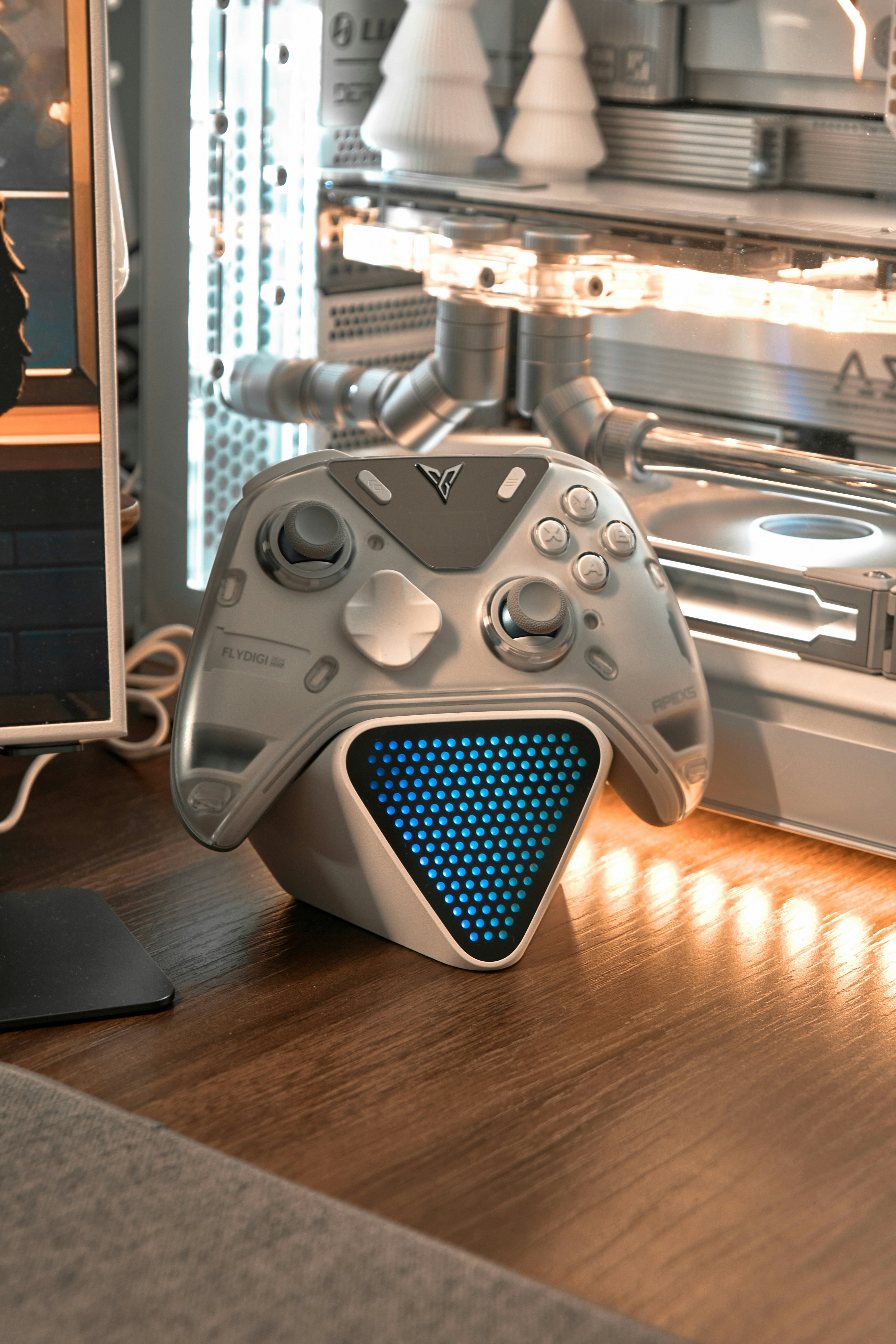 Contemporary Setup: A wireless gamepad rests between a PC case and a glowing blue vent panel