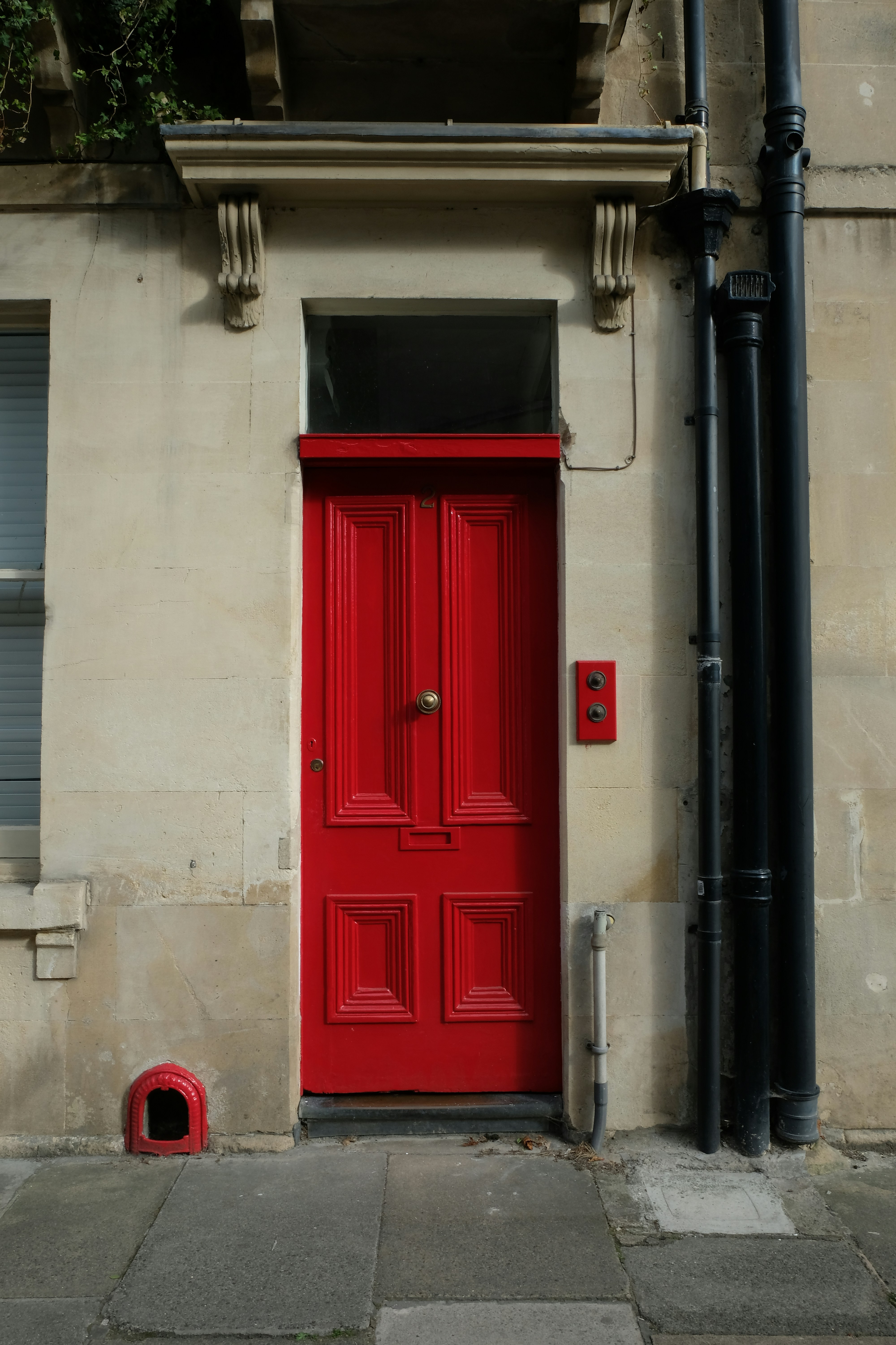Crimson Doorway on a Quiet Urban Wall