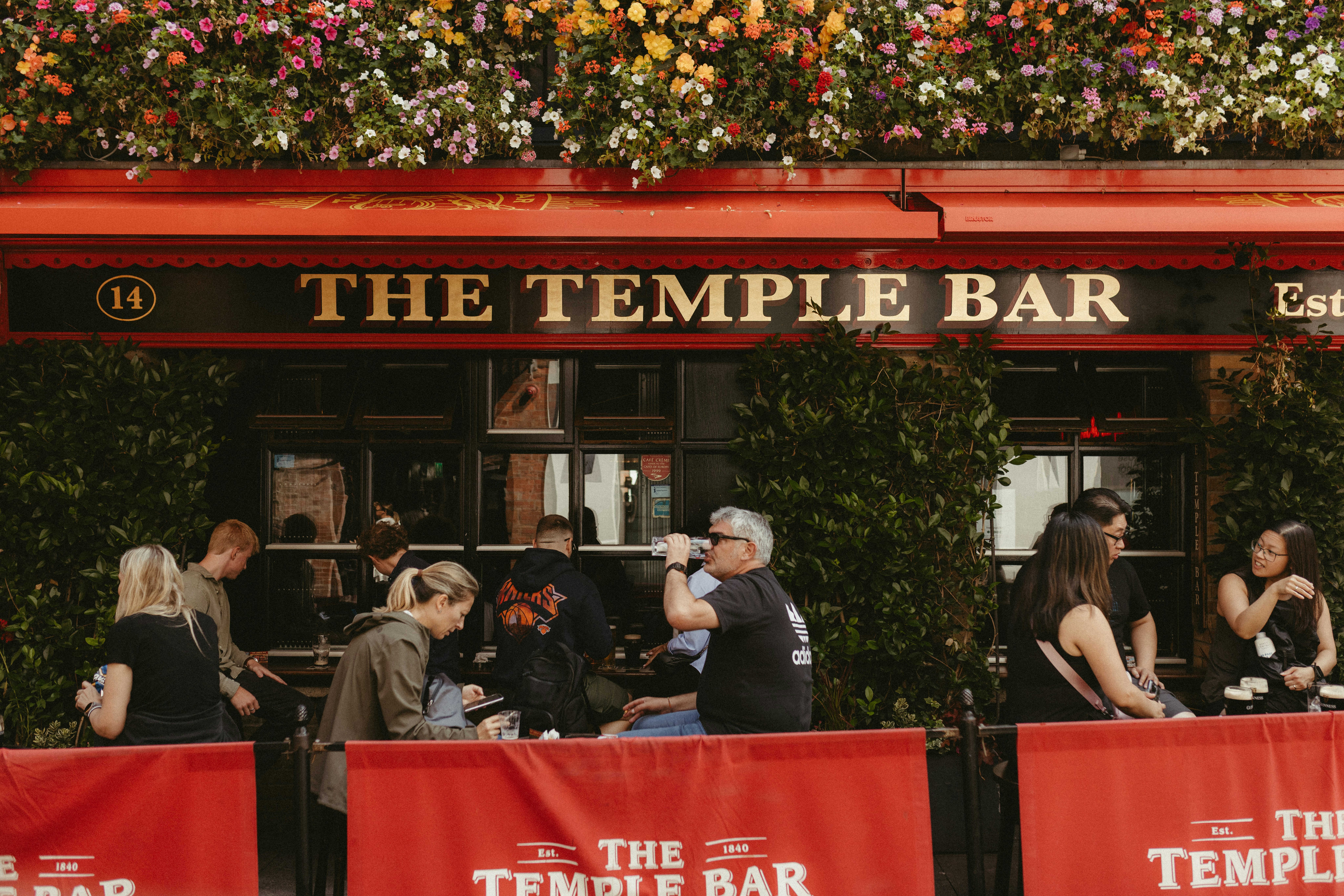 Toast at The Temple Bar: daylight chatter and clinking glasses beneath a floral canopy