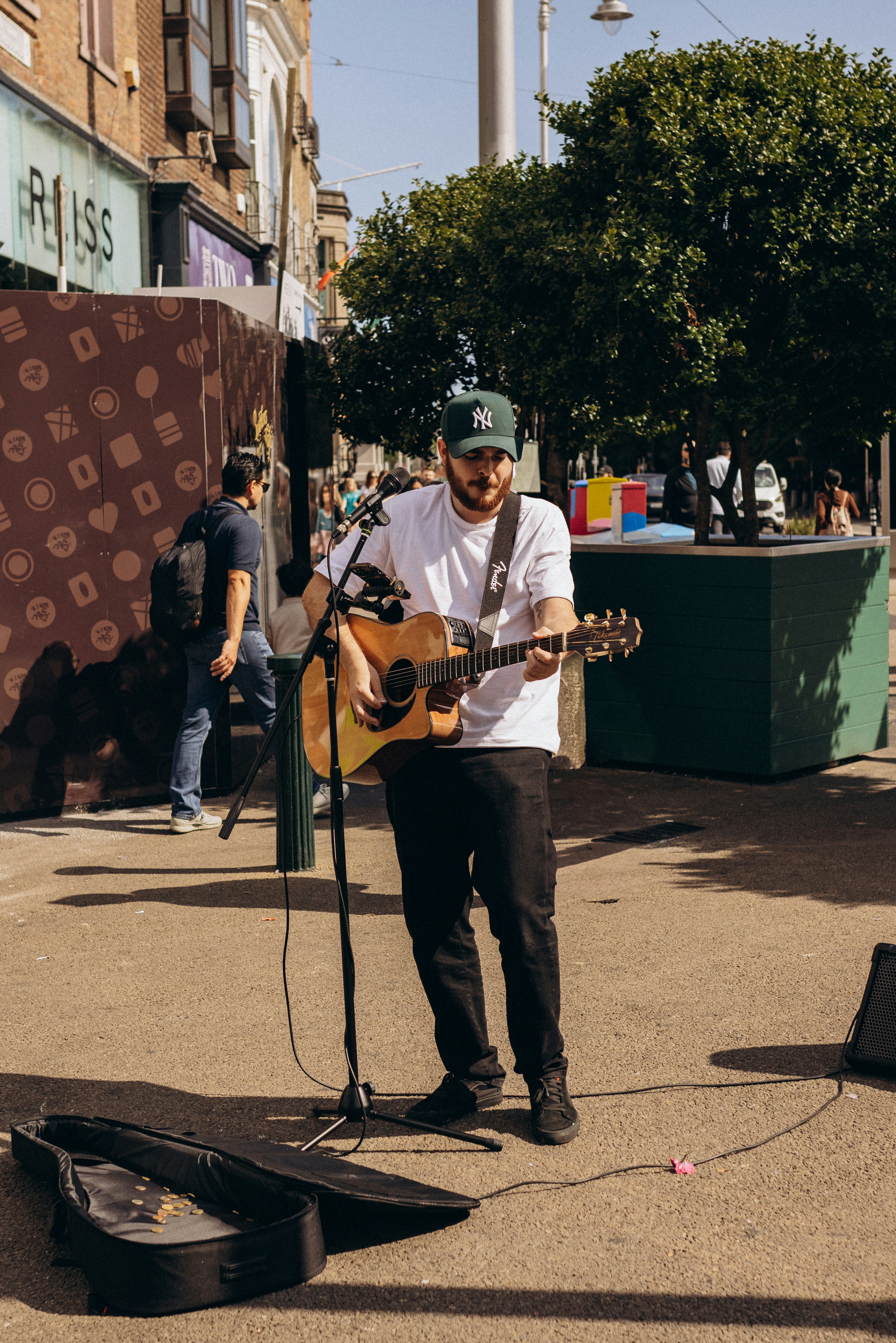 Strummed Street Serenade: The Guitarist Under the Urban Canopy