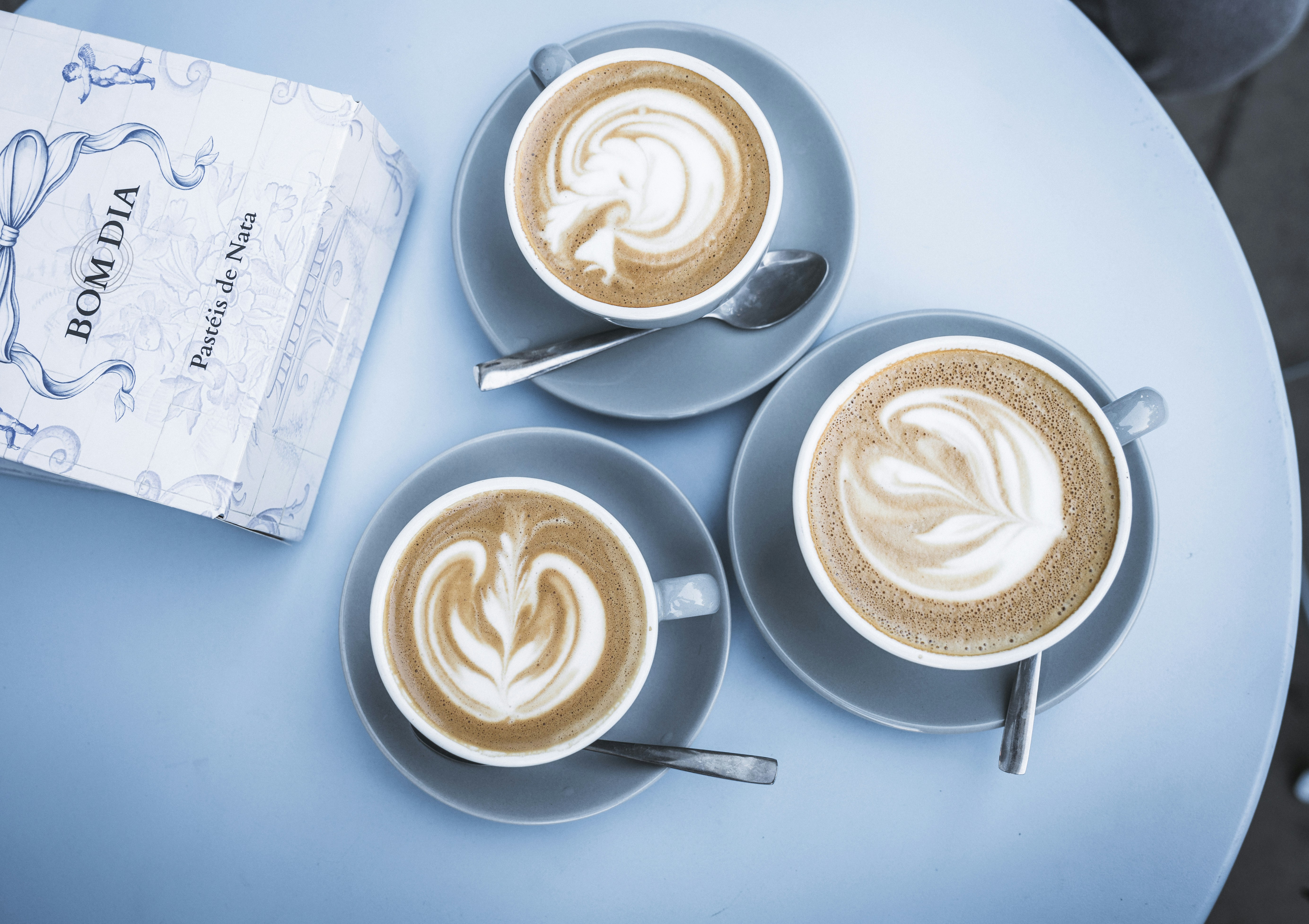 Latte Symmetry: Three Cups on a Blue Table