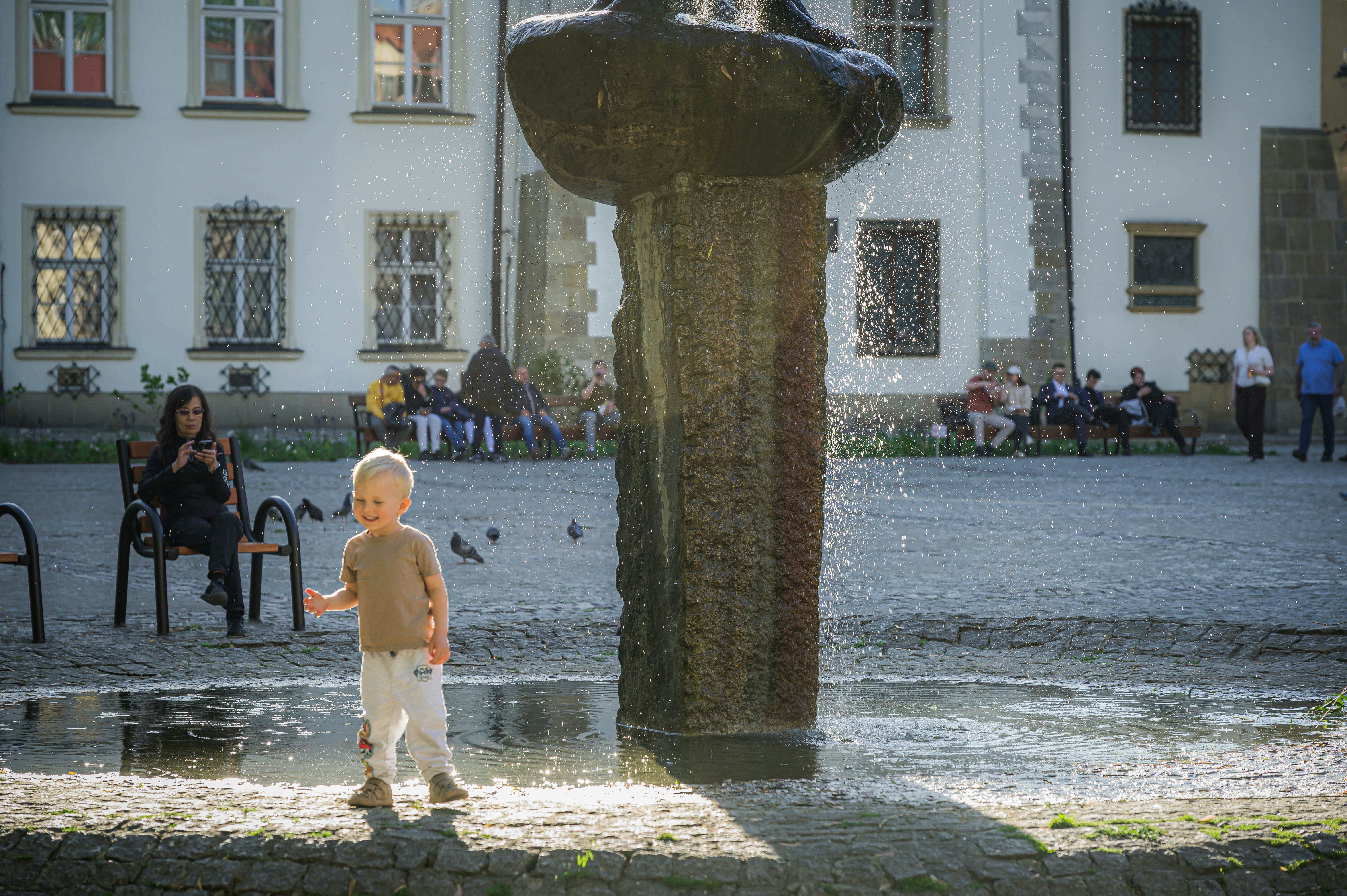 Child at the Fountain: A Sunlit Moment in the Courtyard