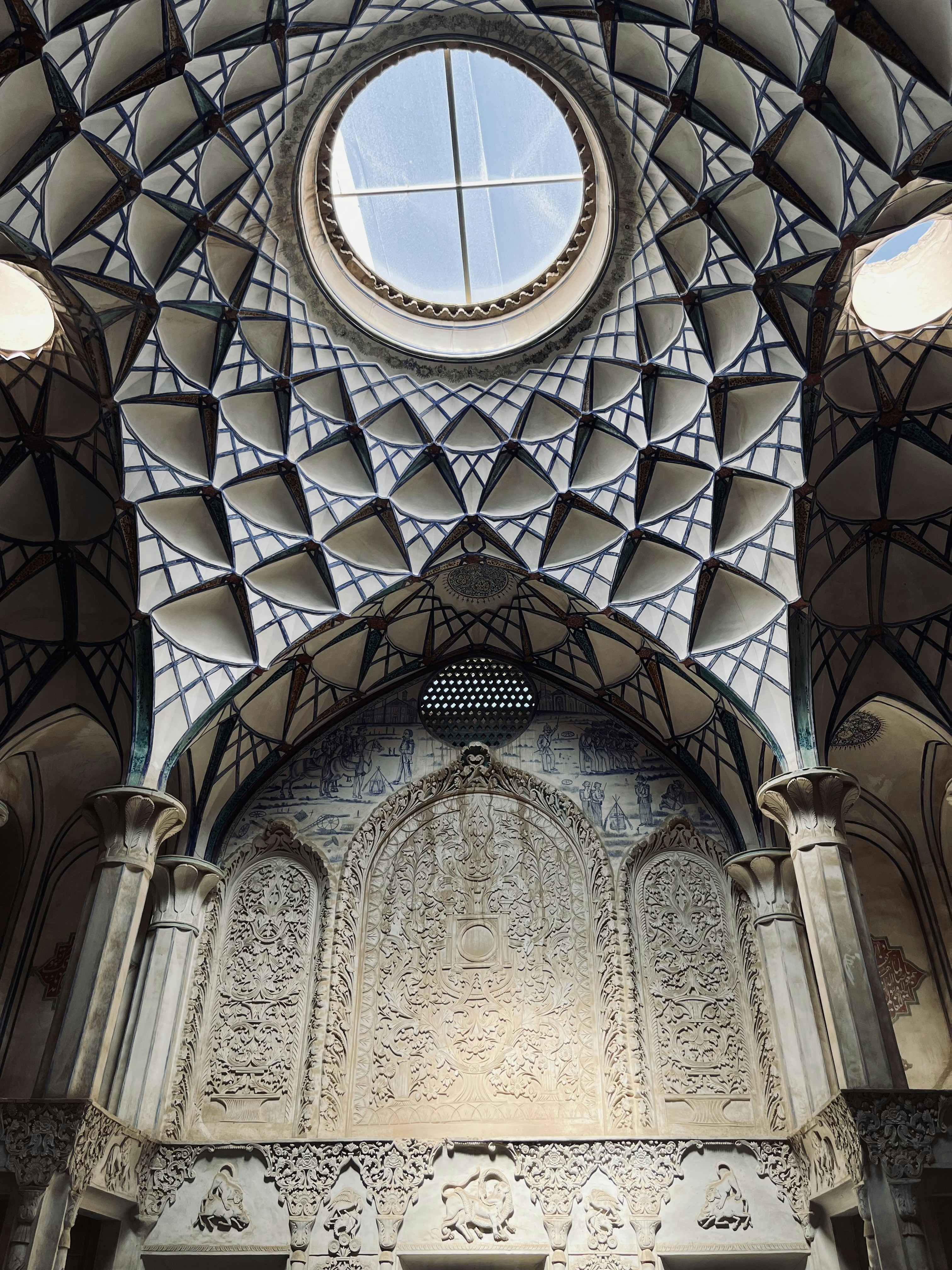 Ornate domed ceiling with geometric patterns and carved walls.