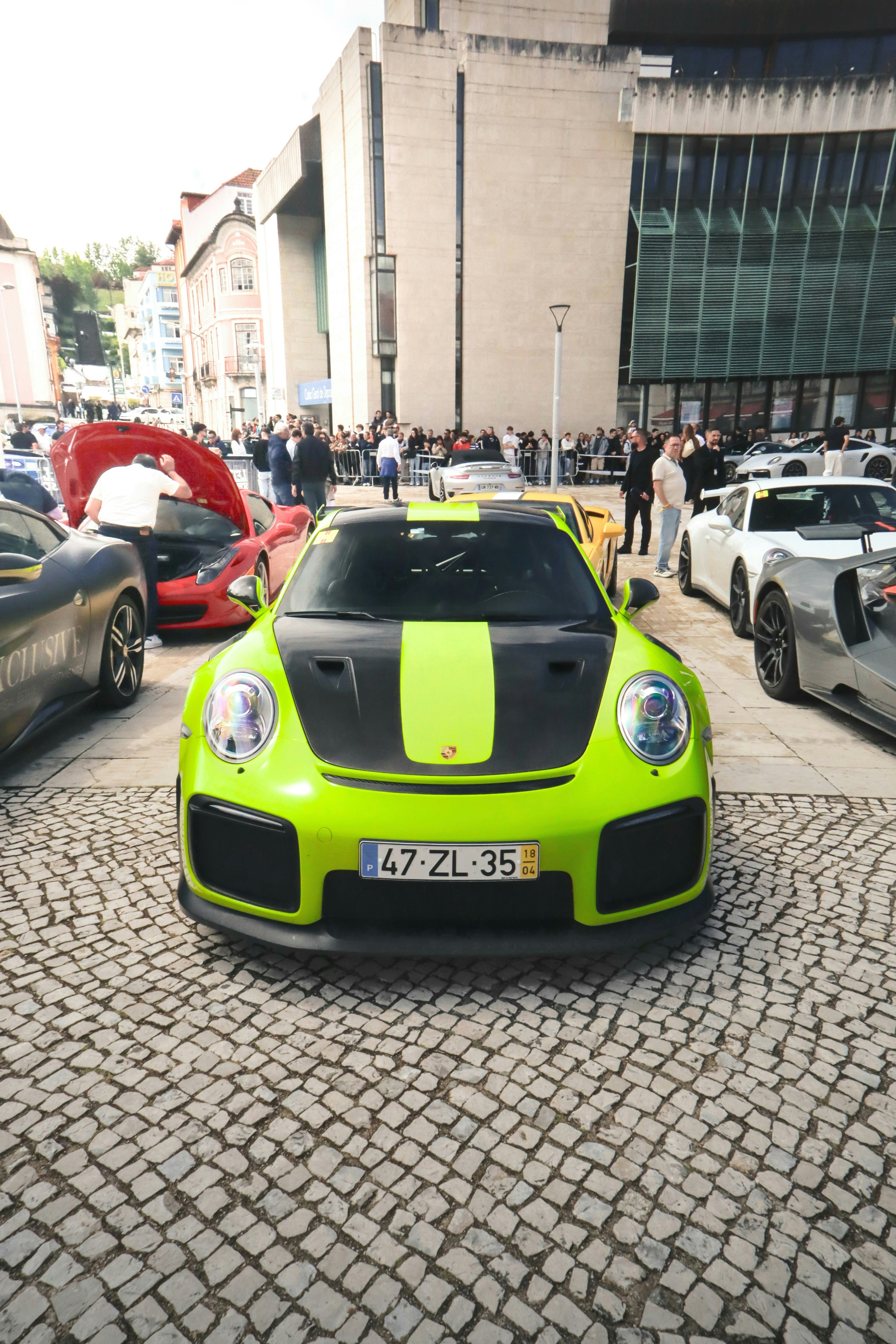 Neon-green Porsche in a cobbled city square Amidst a Verve of Exotics