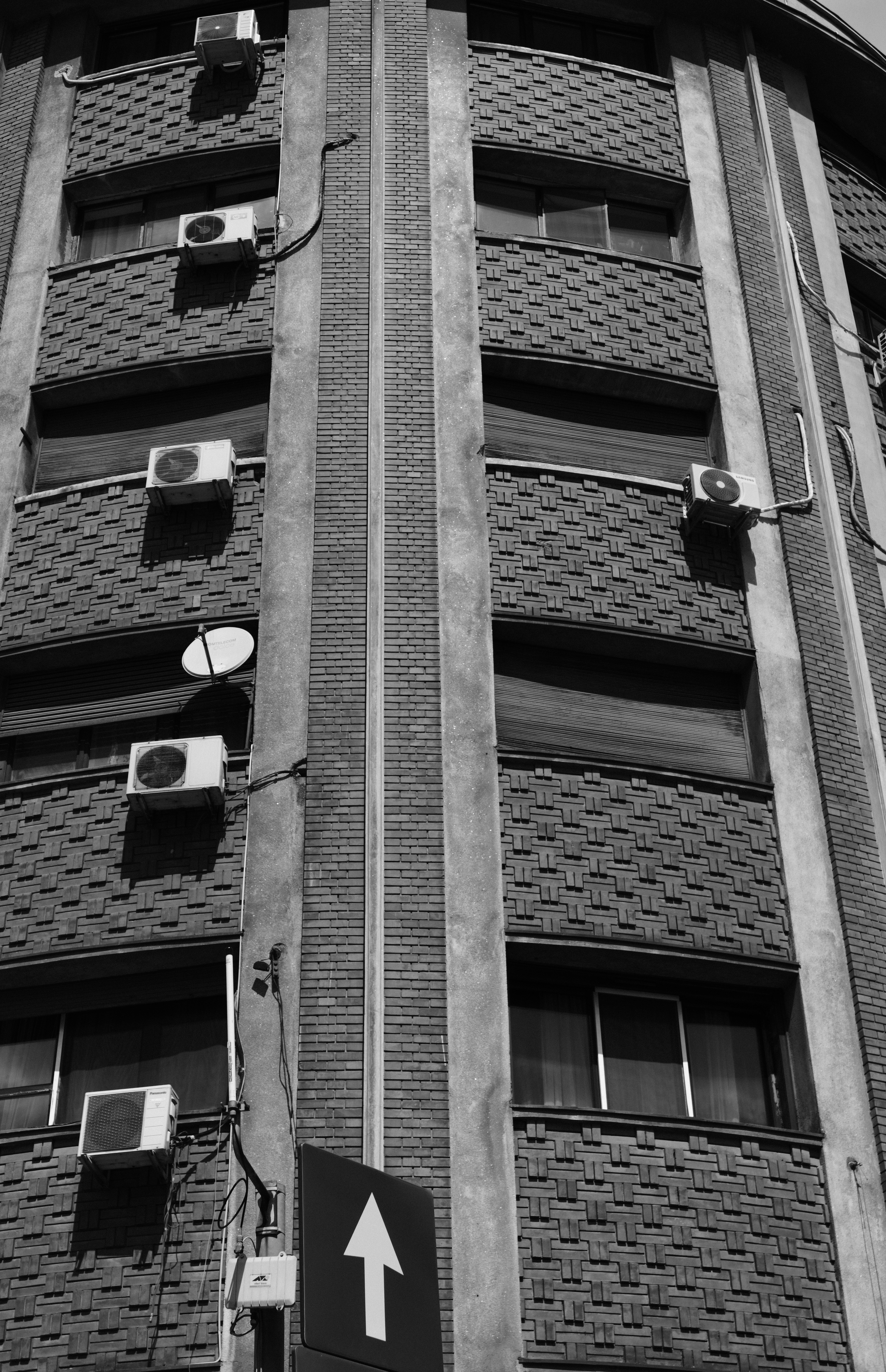 Vertical Facade: A Monochrome City Silhouette of Repeating Bricks and HVAC Units