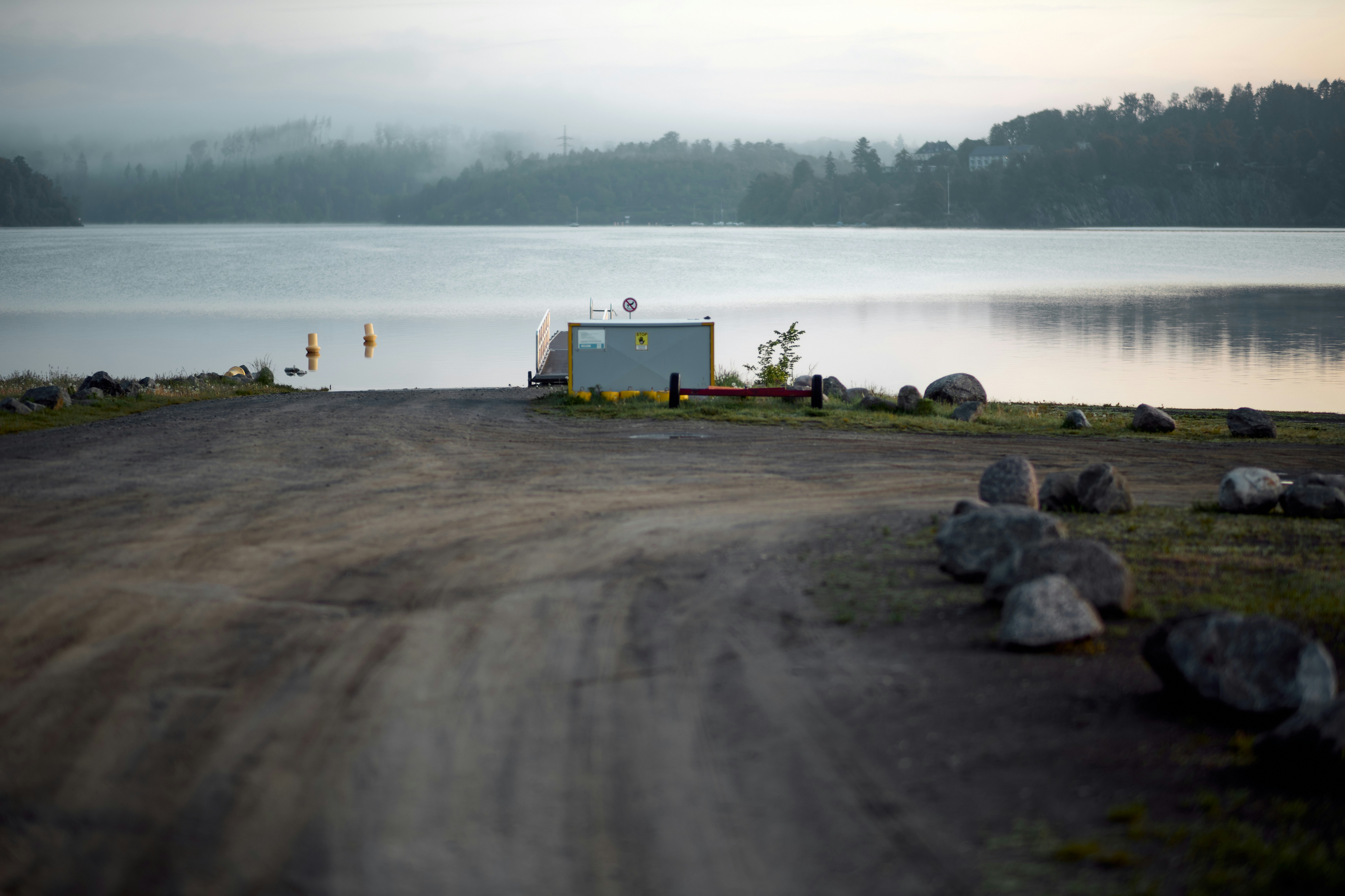 Misty morning at a lake with a boat ramp.