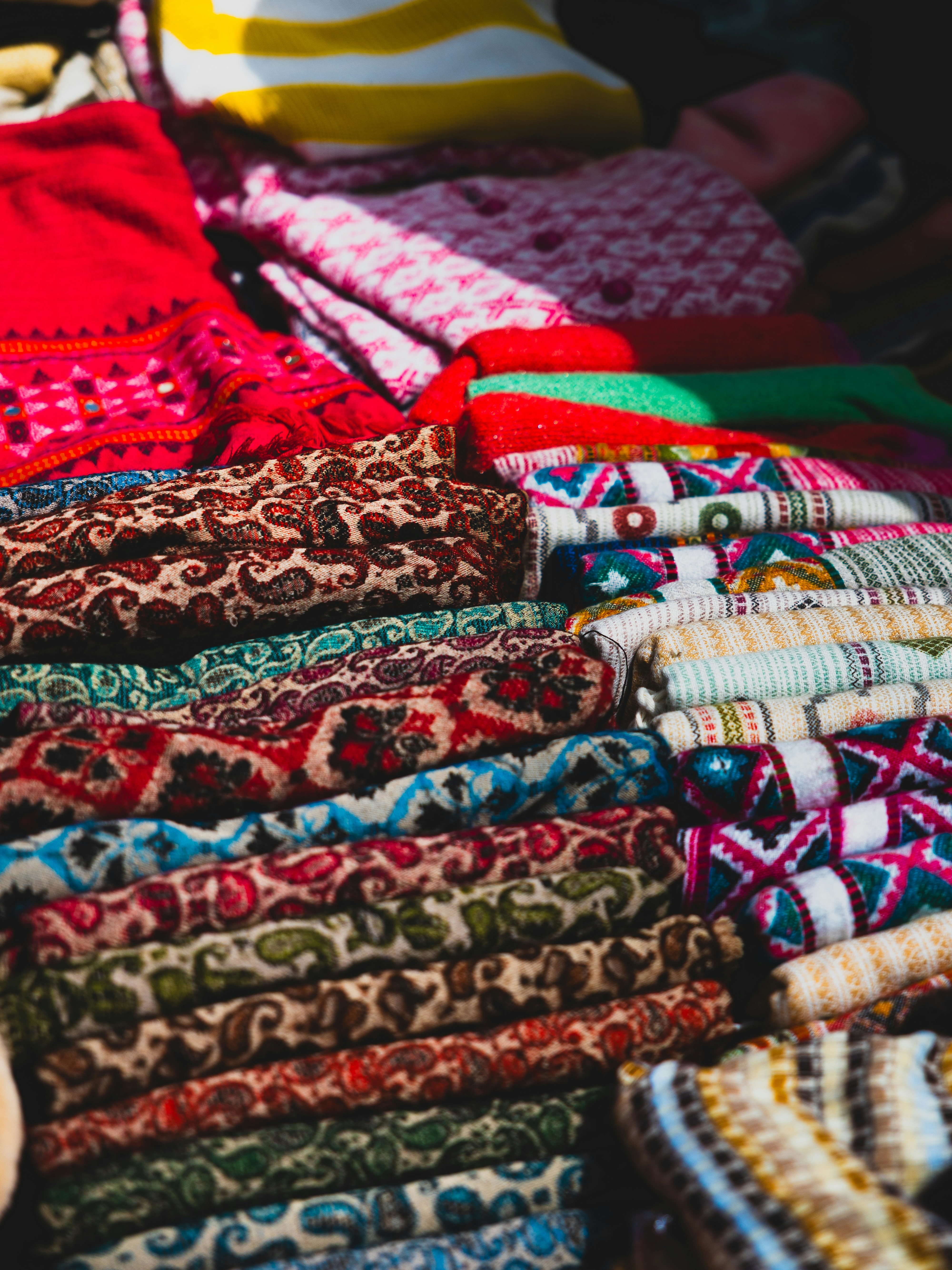 Colorful Textile Tapestry: Rolled Patterns in a Market Stack