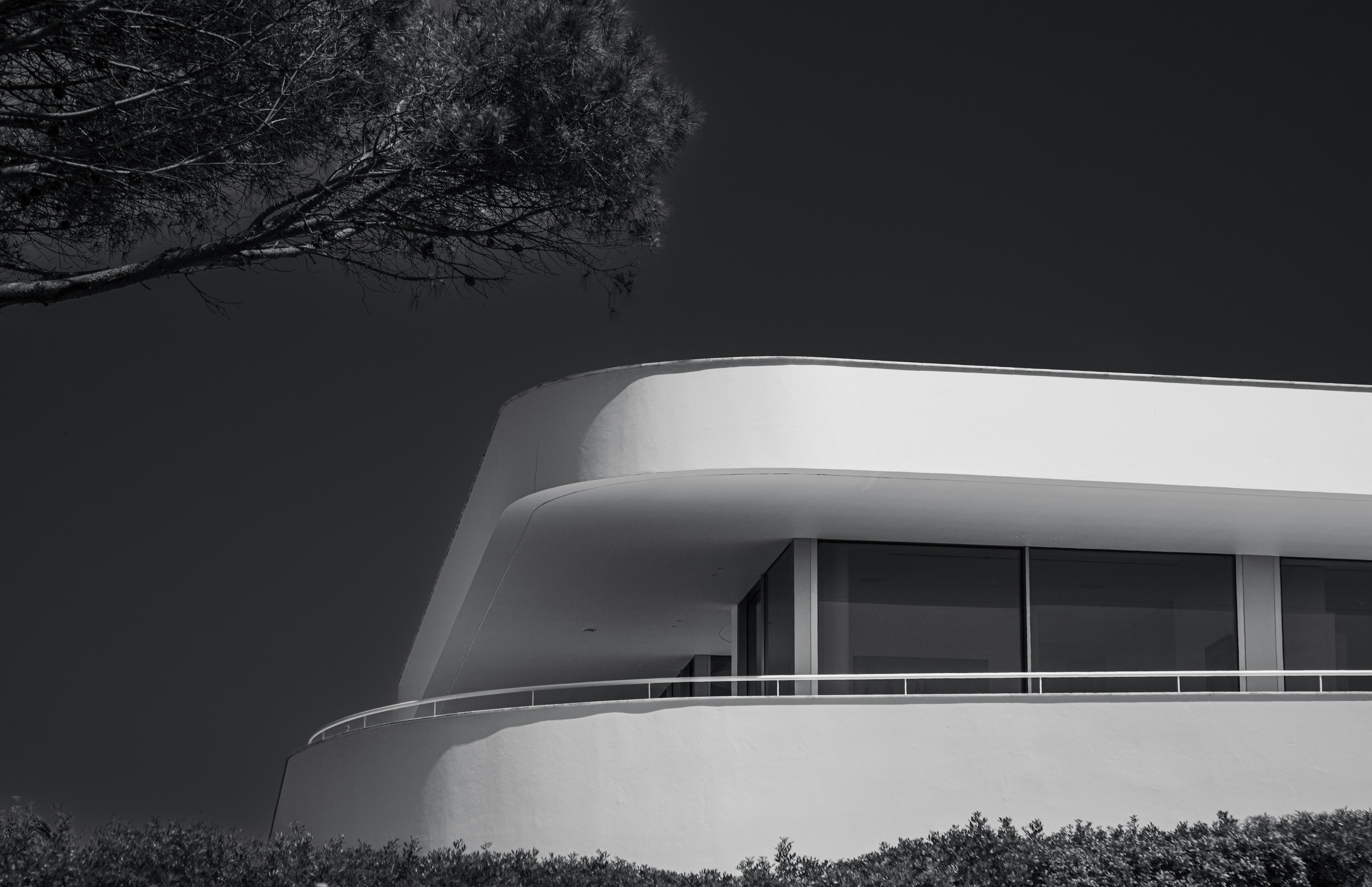 Minimalist Modern: Curved Terrace of White Form Meets Quiet Sky