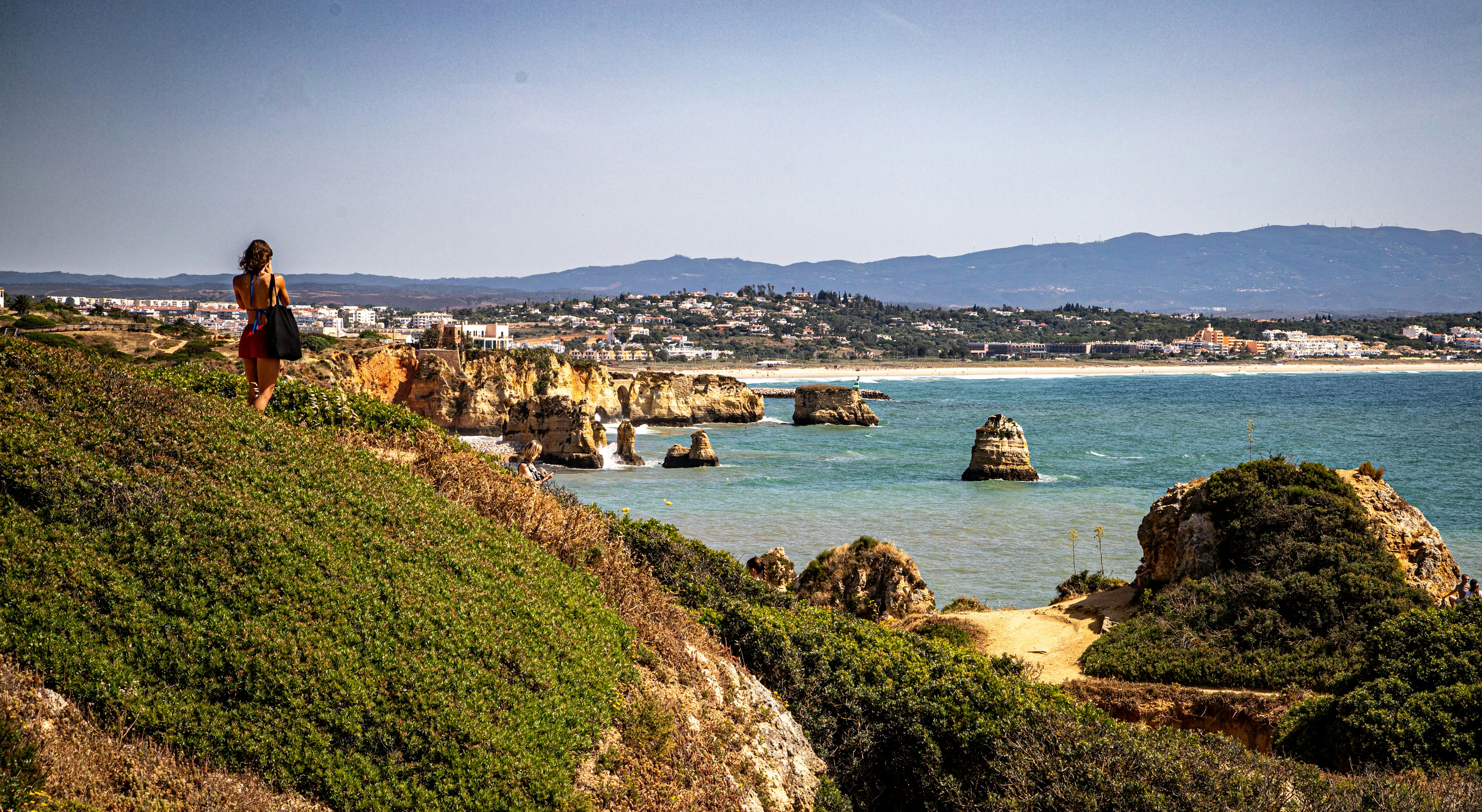 Coastal Path: lone figure gazes toward distant cliffs and sea