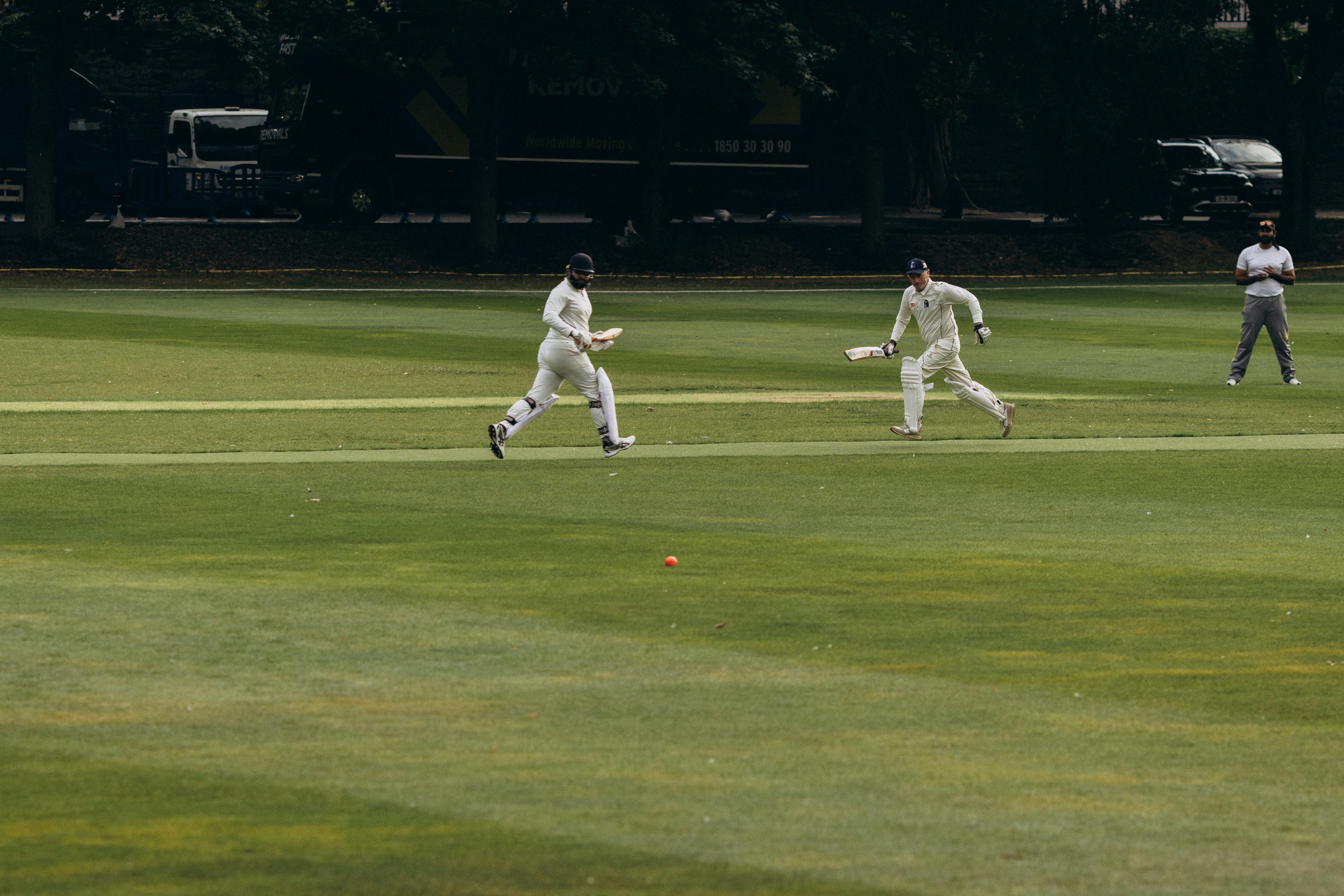 Cricket Field Dash: Two Batsmen Converge on a Low Bowling Crest