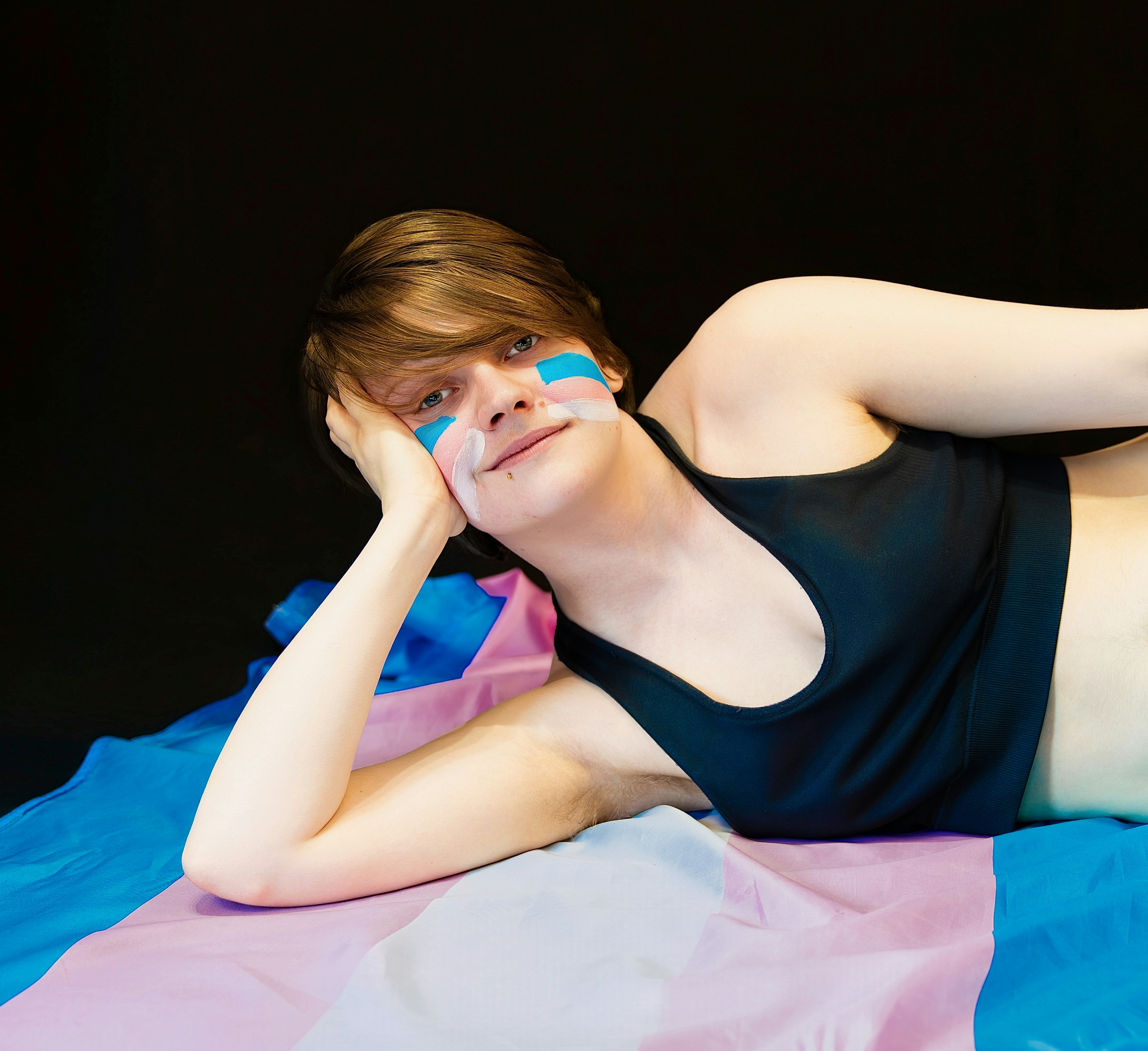 Blue-masked repose: a playful portrait on pastel sheets