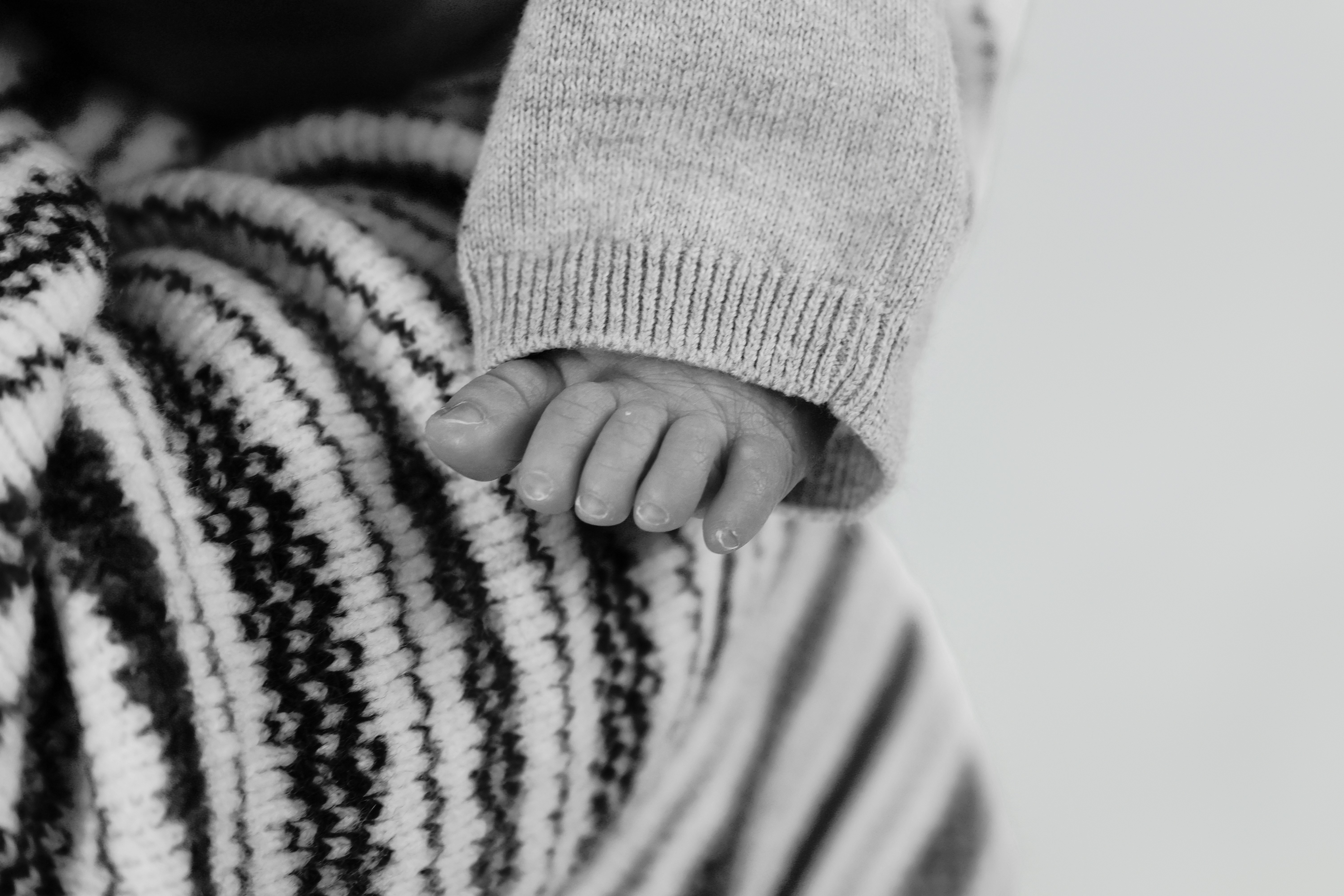 Gentle Grip: A Tiny Hand Welcomes a Soft Blanket Moment