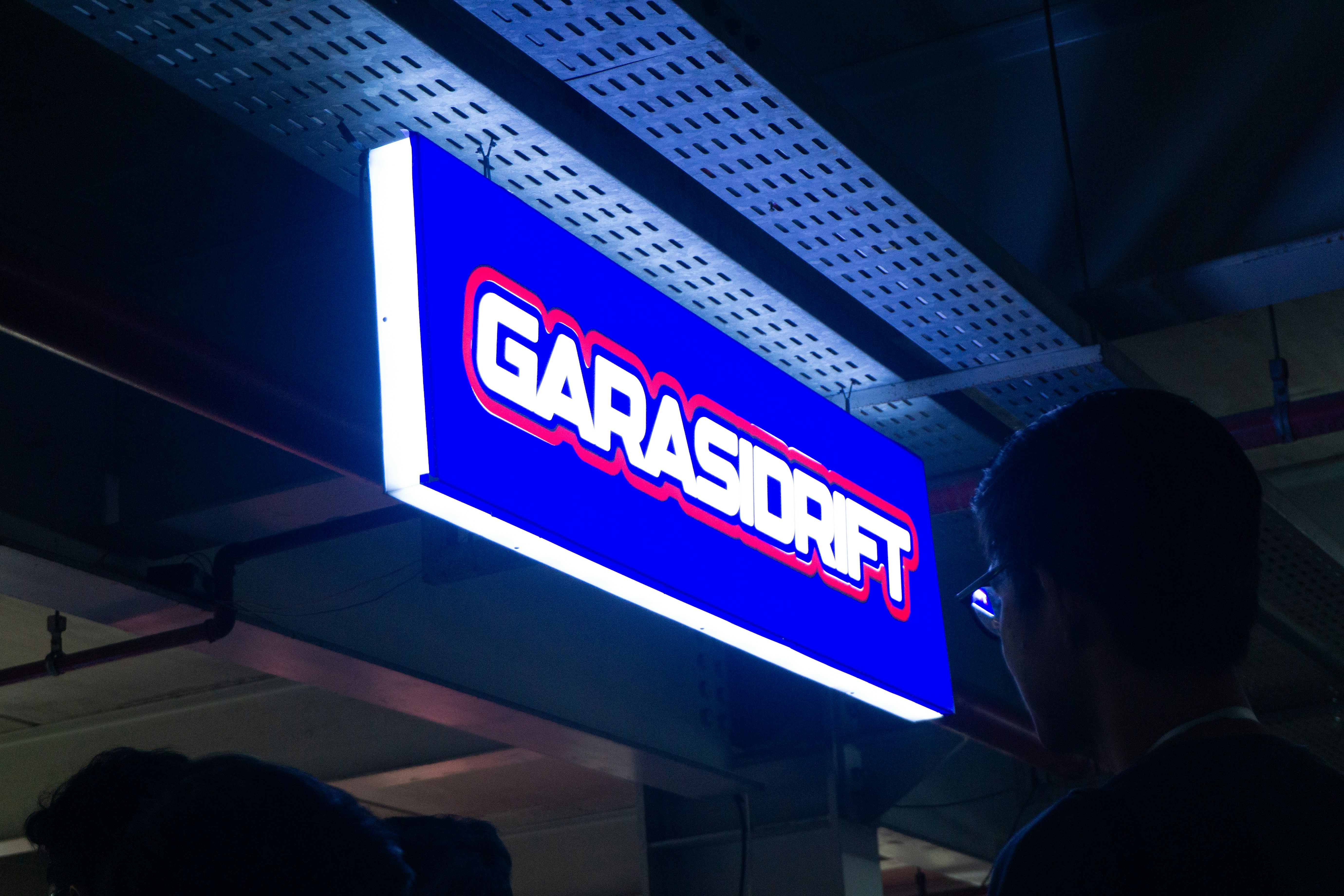 Neon Sign Overhead at Night: GARAGECRAFT Glows in Blue