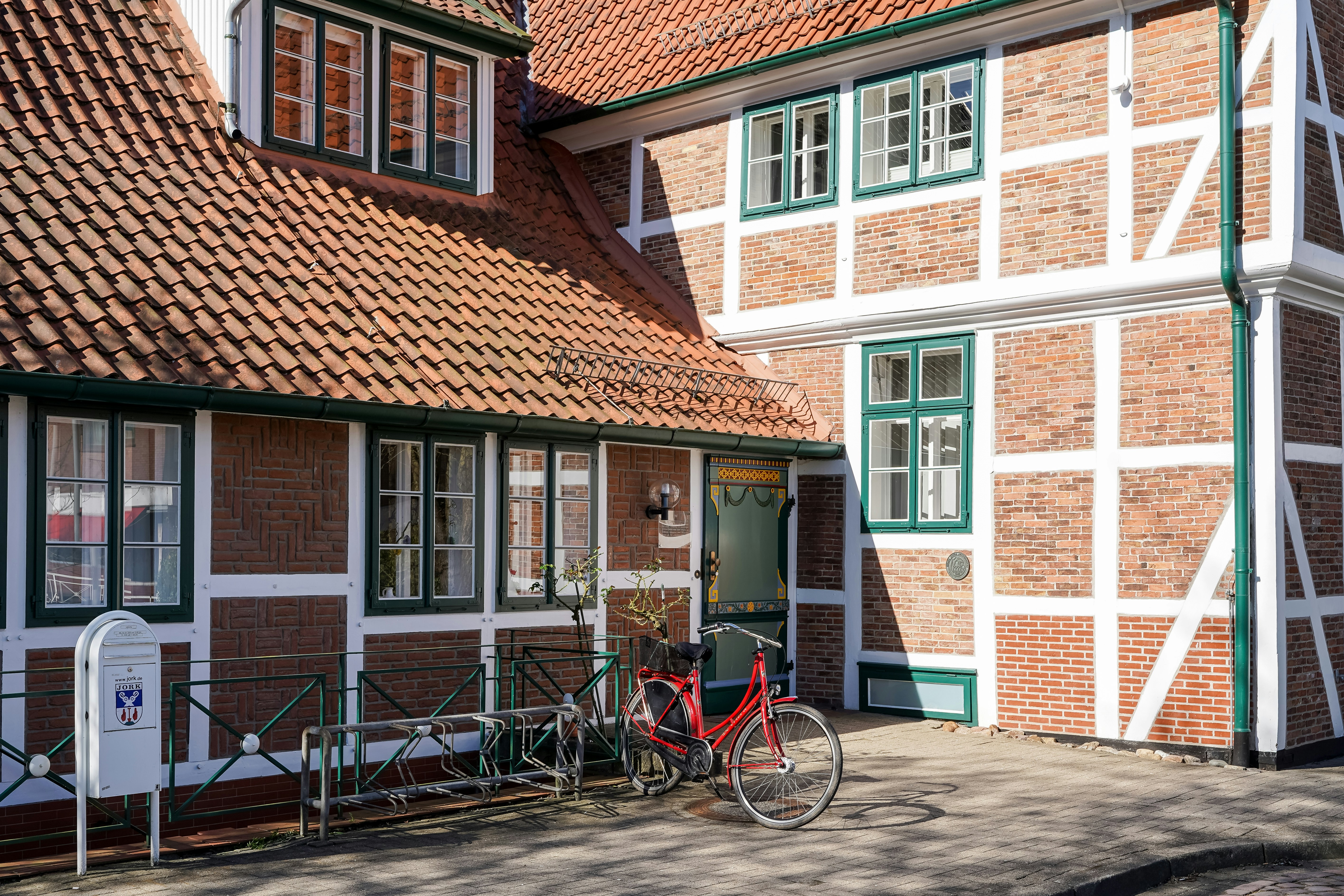 Traditional half-timbered building with a red bicycle parked outside.