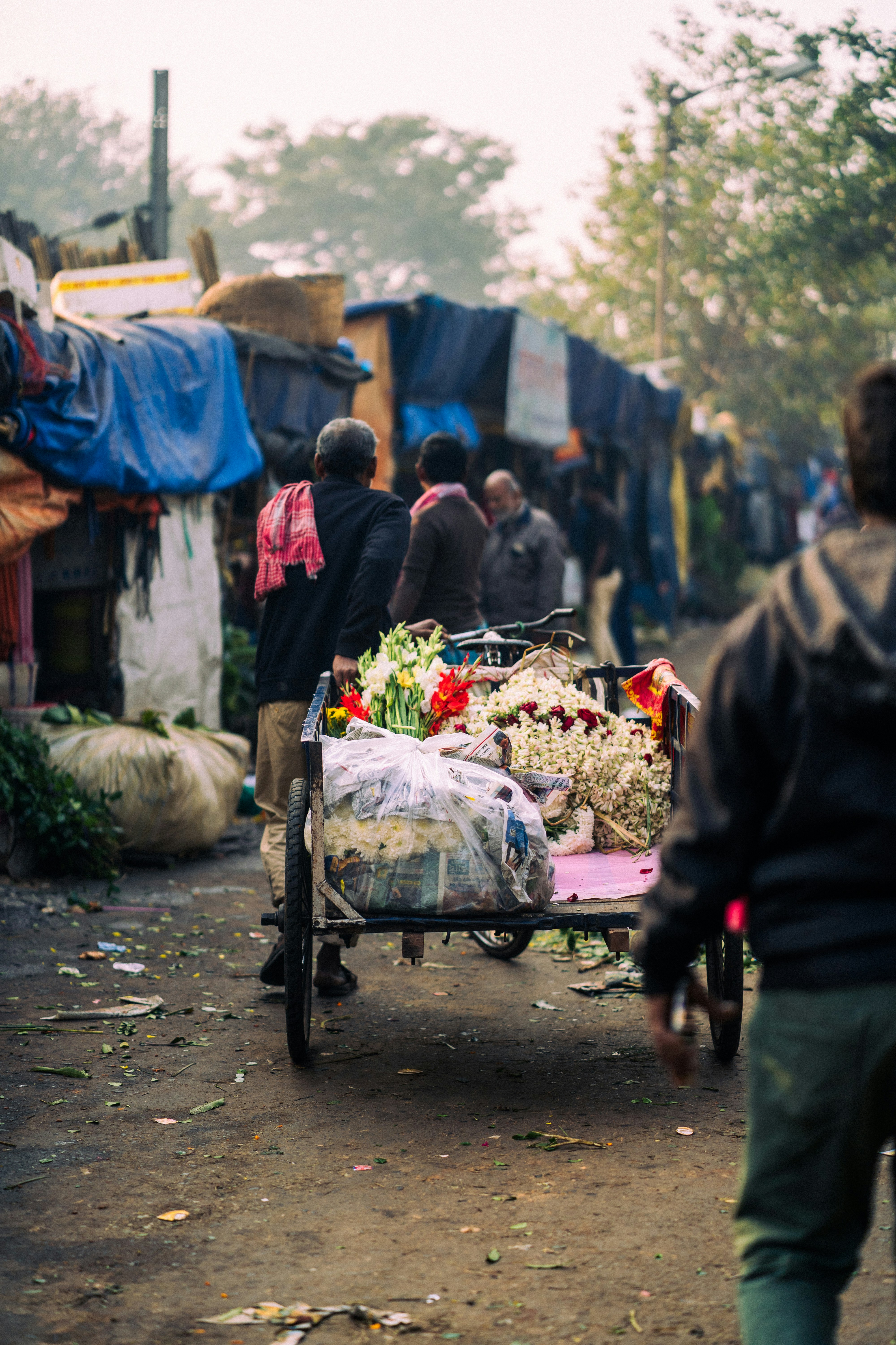 A Market Cart Framed by Tents and People in Motion