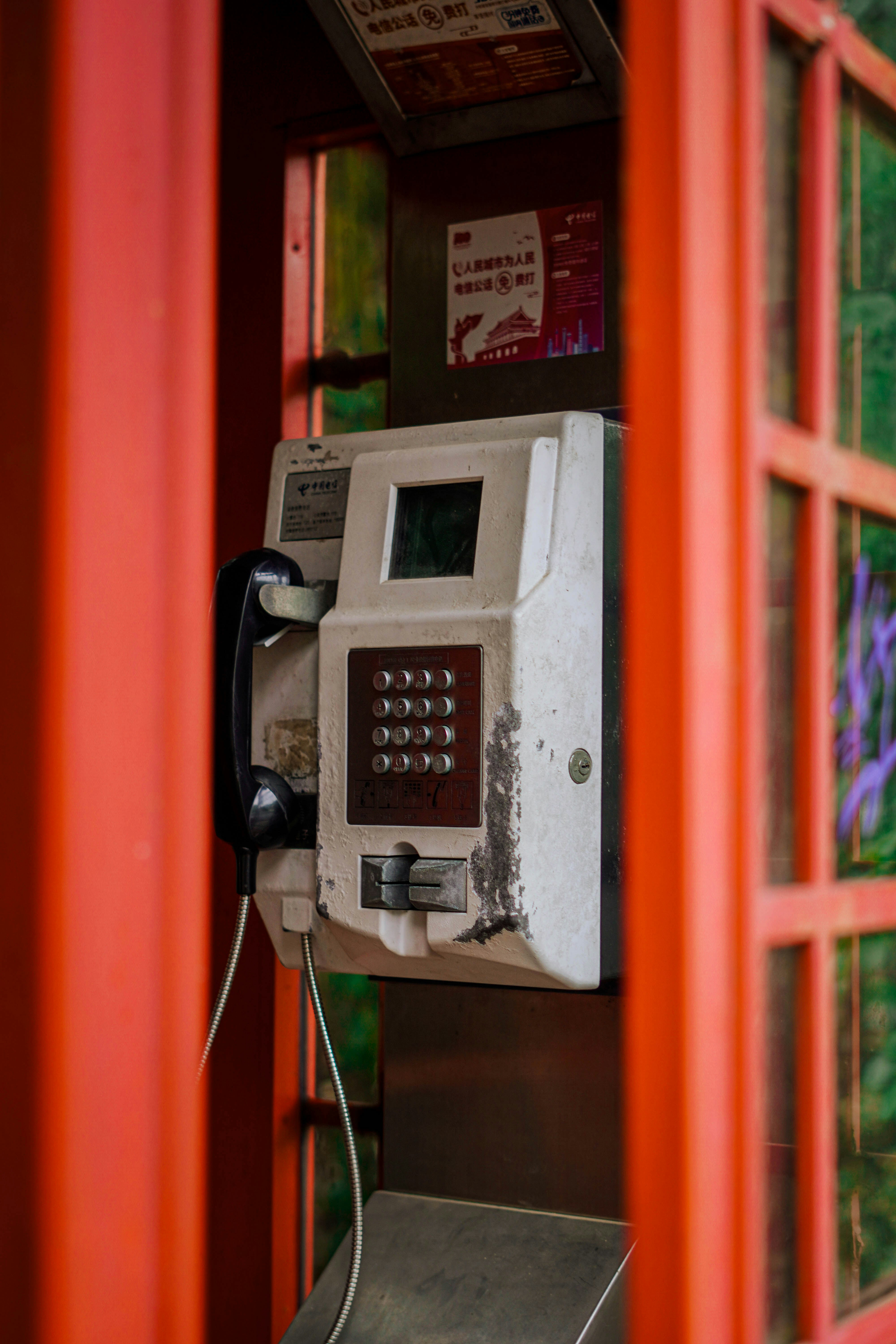 Red Payphone in a Narrow Corridor