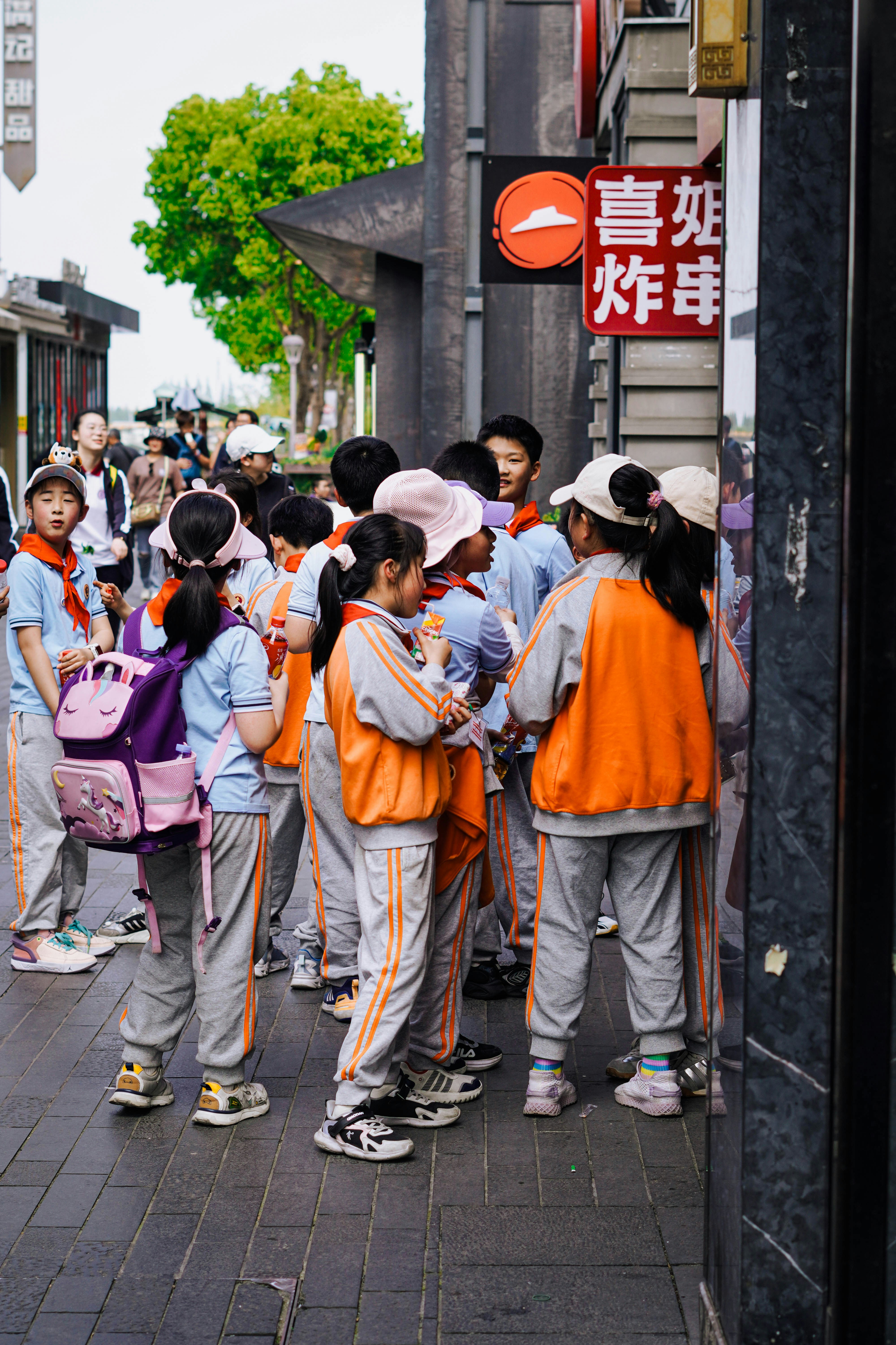 Orange-vested Class in a Busy Street