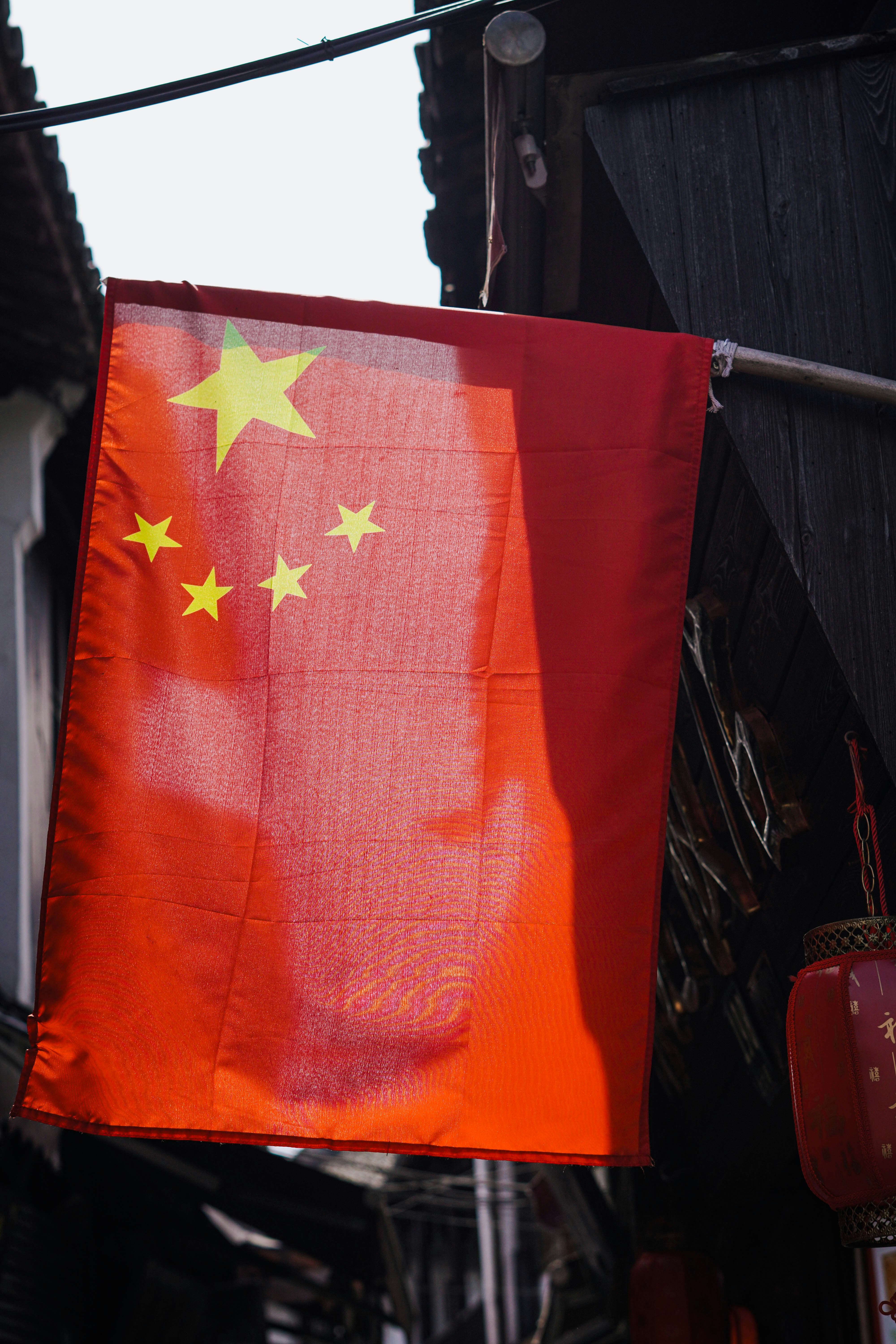 Red Banner of a Free City: The Chinese Flag Fluttering in a Narrow Alley