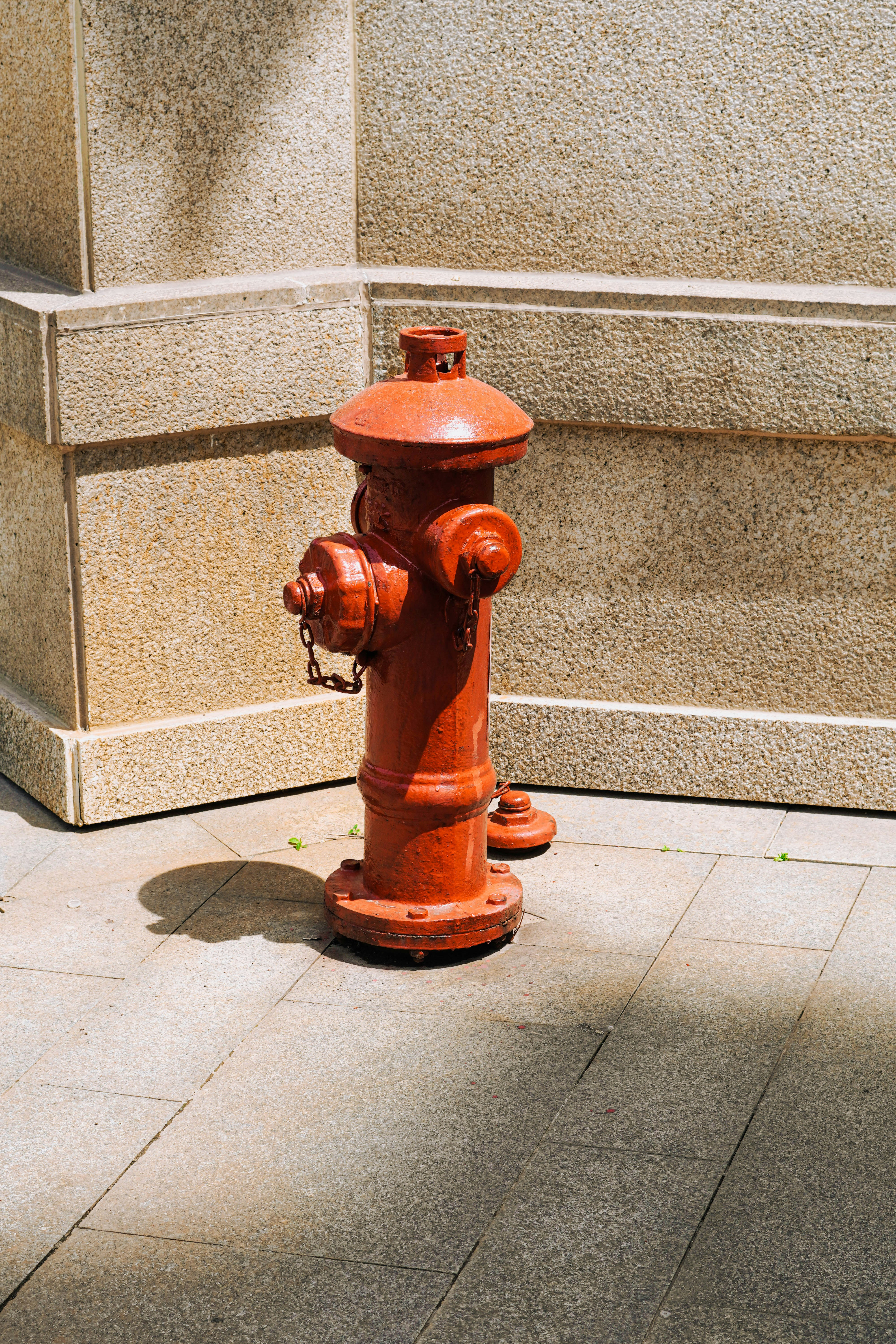 Red Hydrant Stood Against Granite: A Quiet Urban Moment