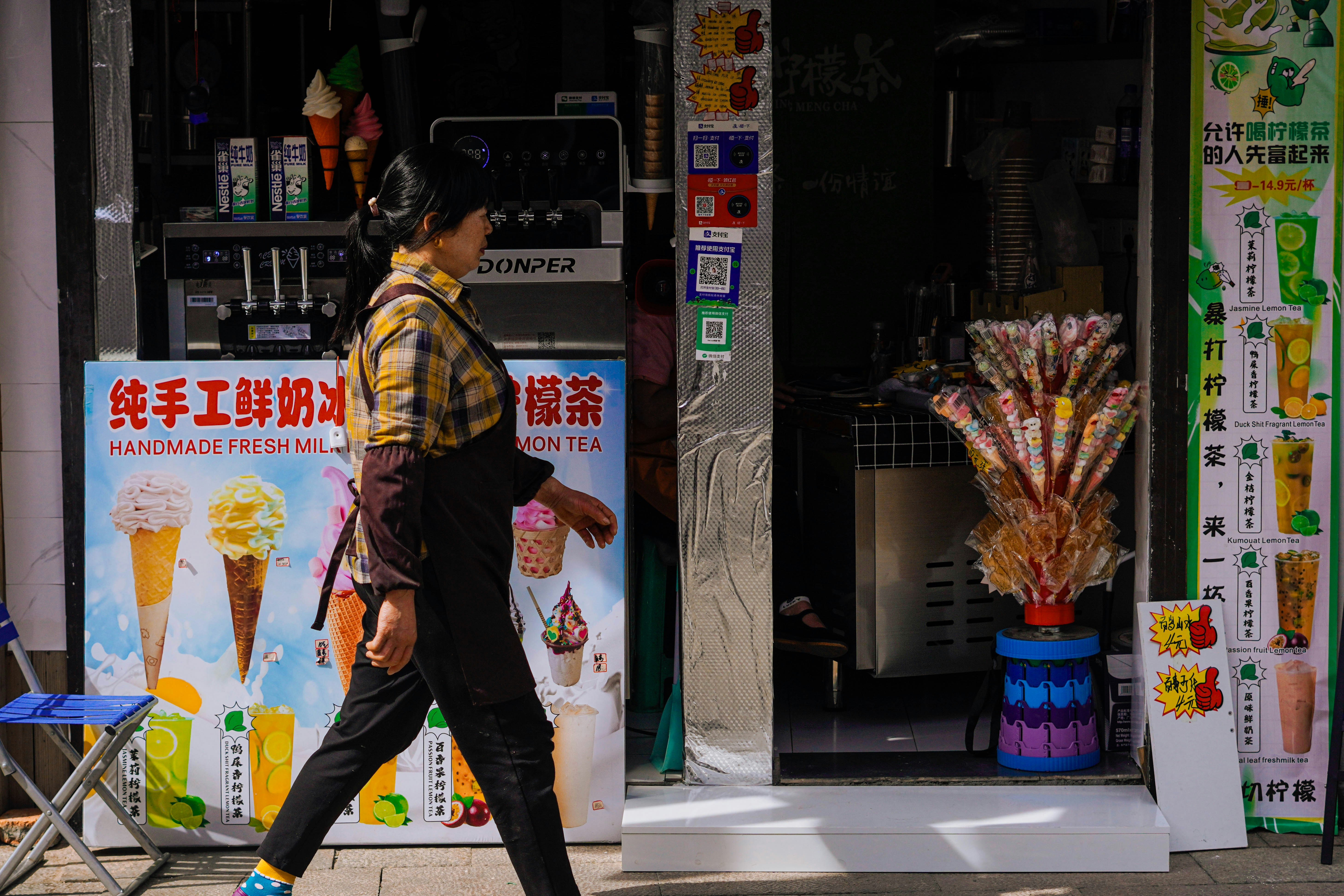 Stride Through the Shop: A Customer Passes by Colorful Treat Stands
