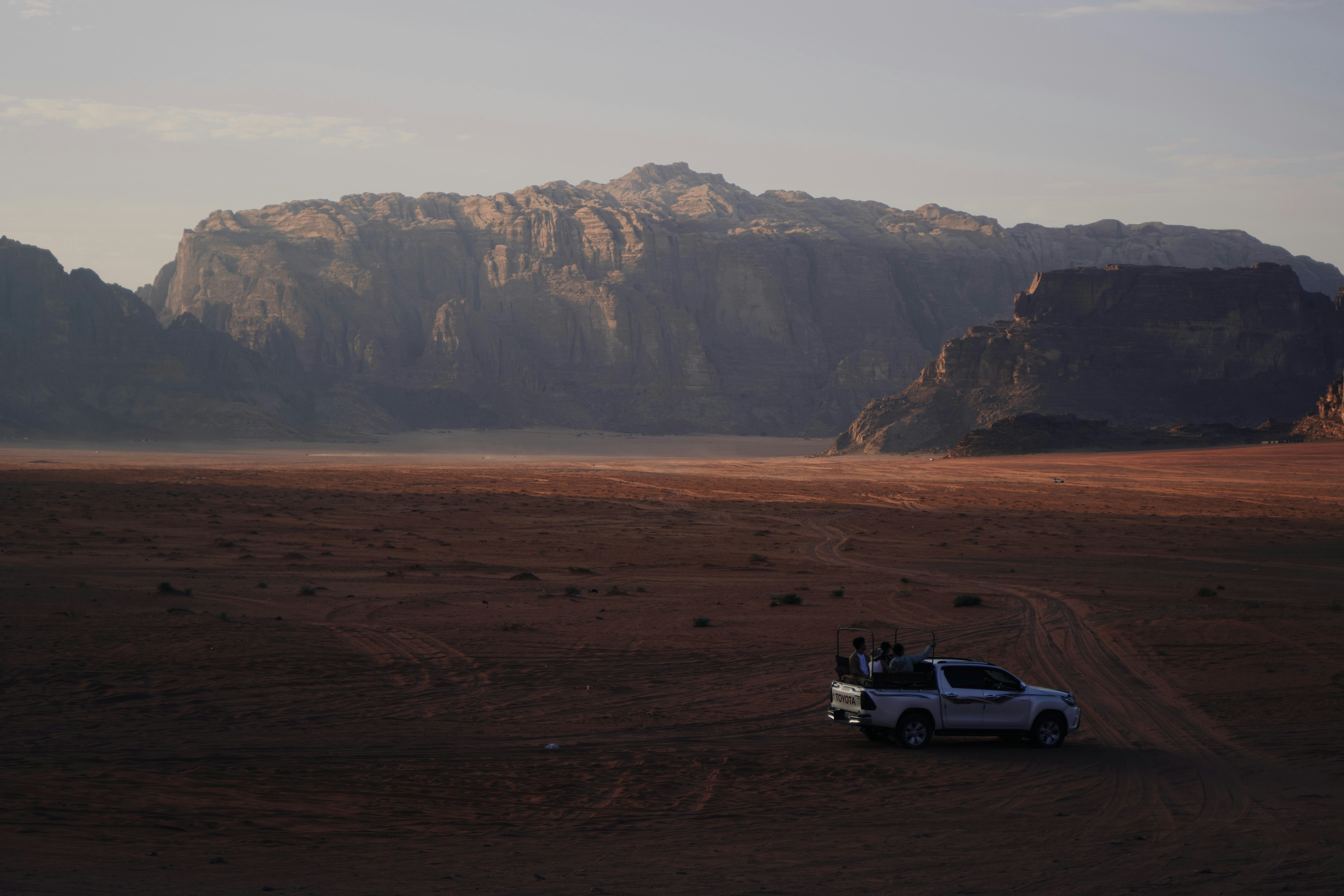 Dusty Desert Caravan Beneath Towering Canyon Walls