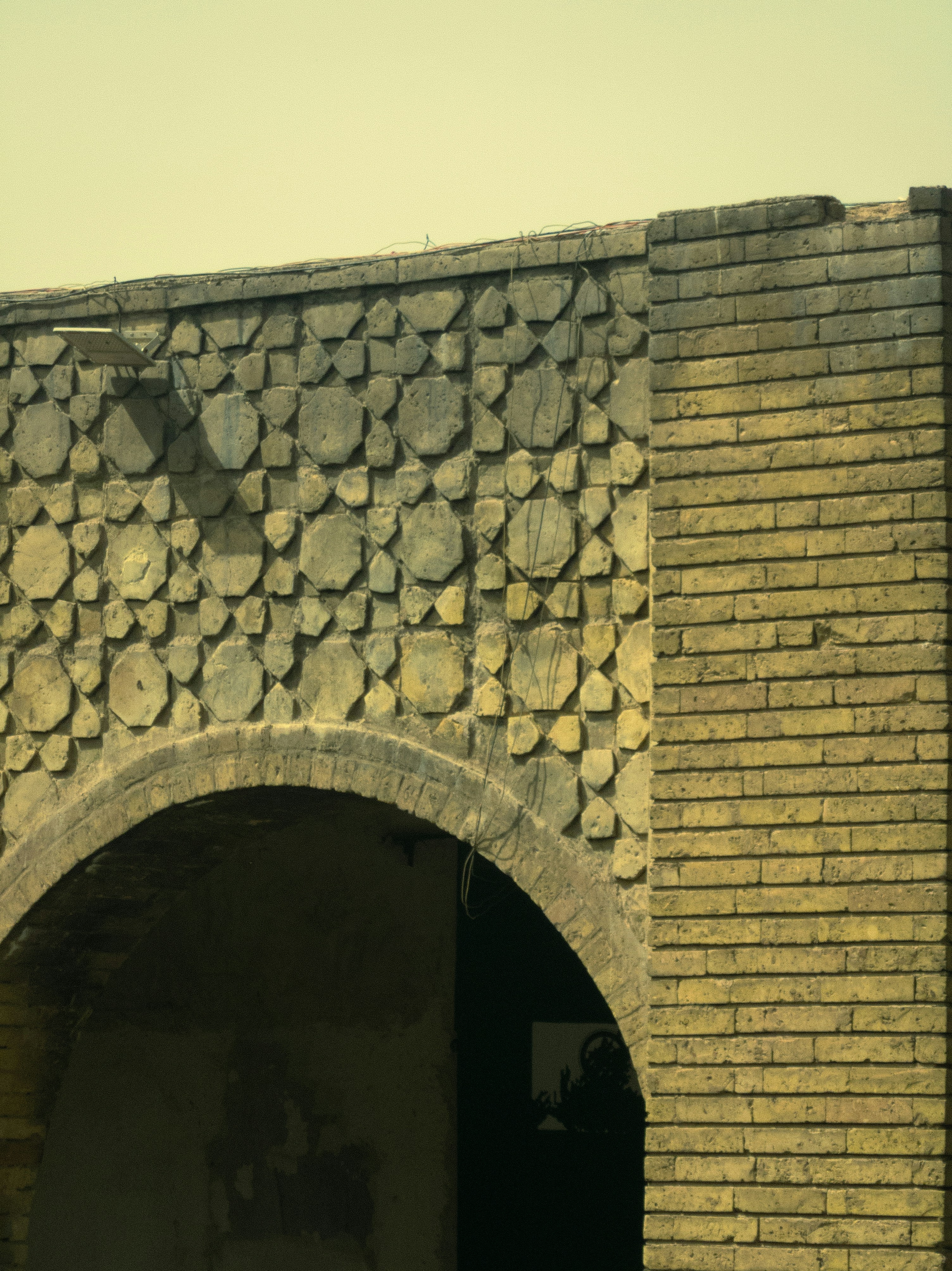 Archway Echoes: Stone Mosaic and Brick Boundary