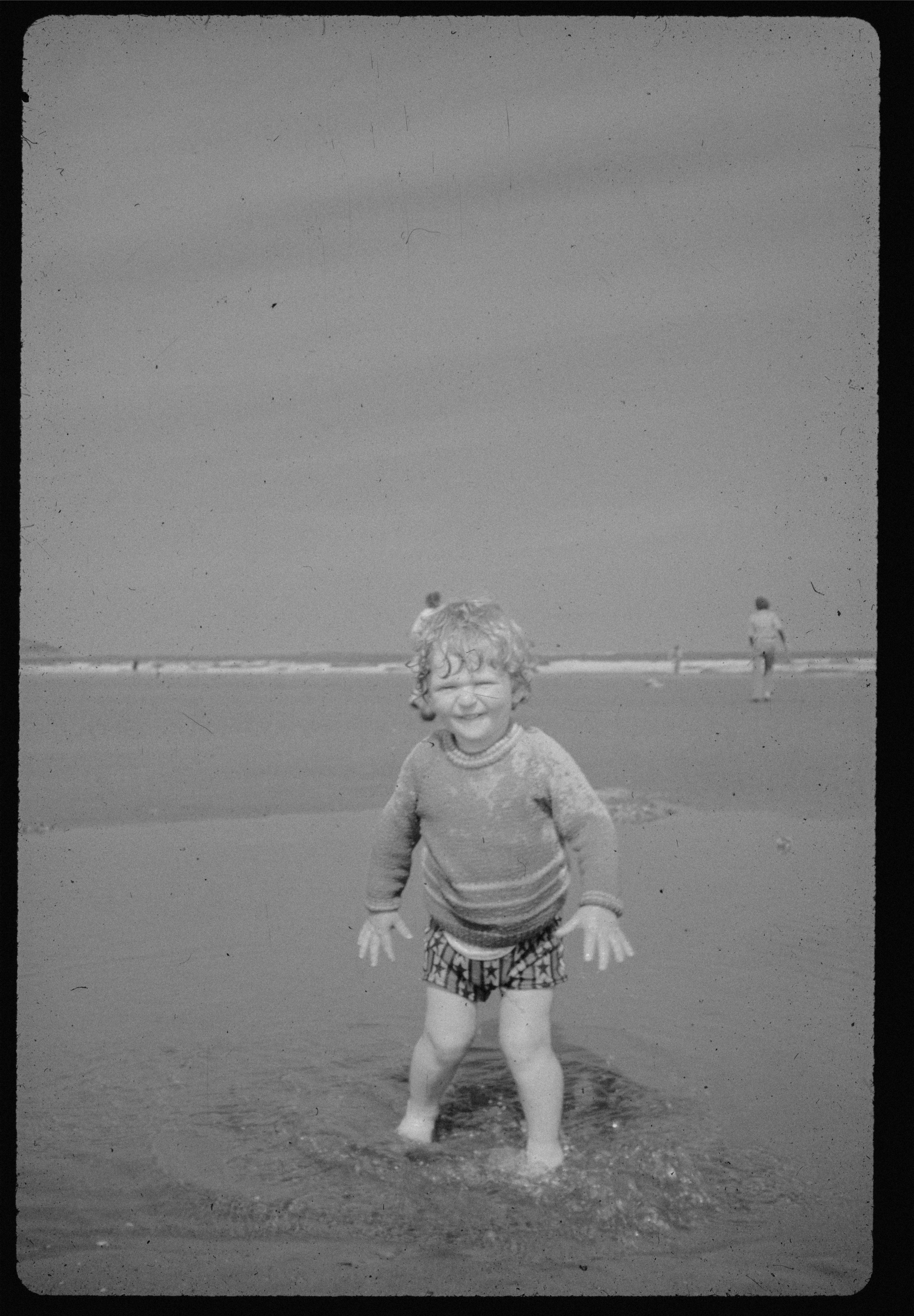 Child at the Shore: A Playful Splash in Grainy Blue