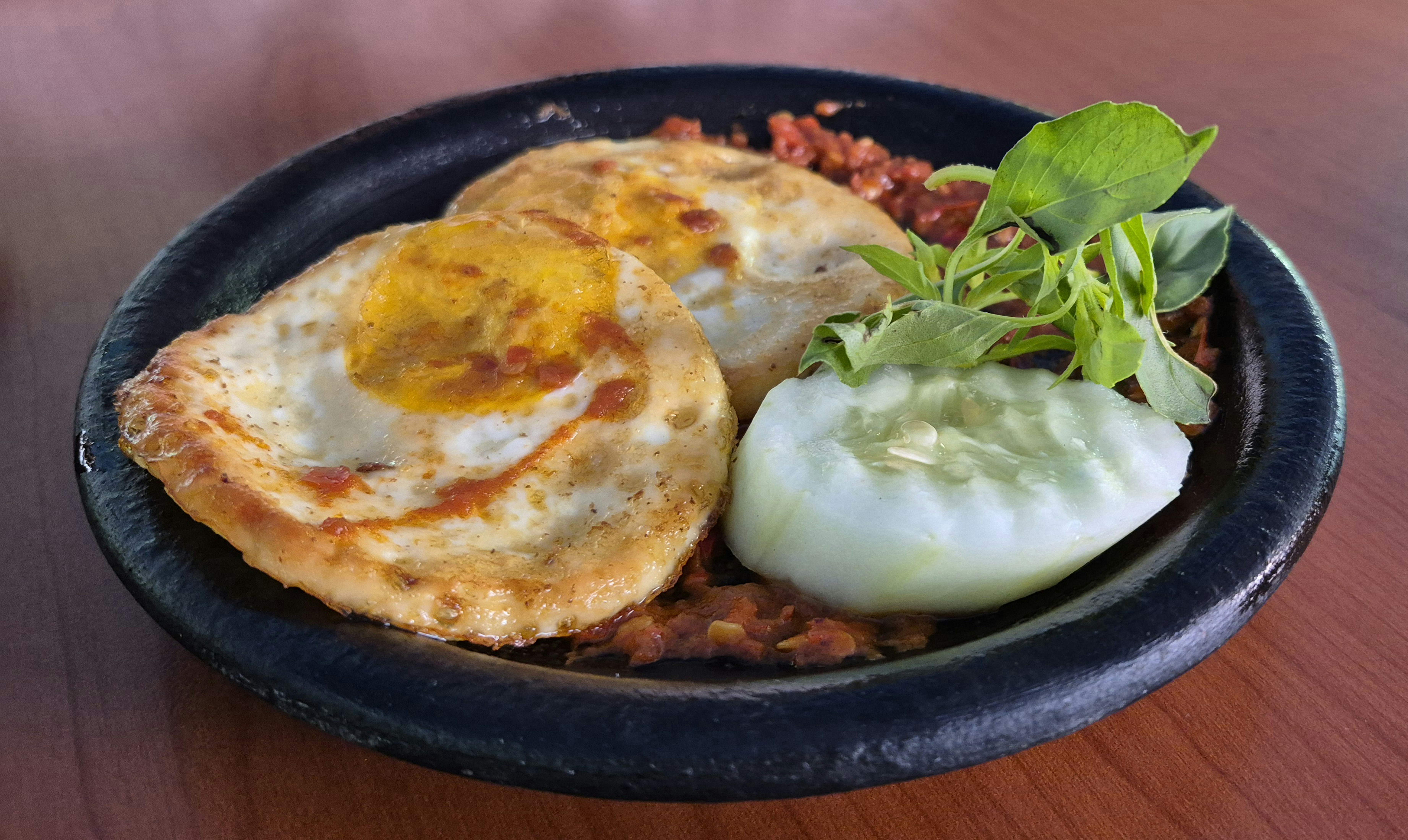 Golden Eggs on a Rustic Skillet: A Savory Duo with Fresh Cream and Topping