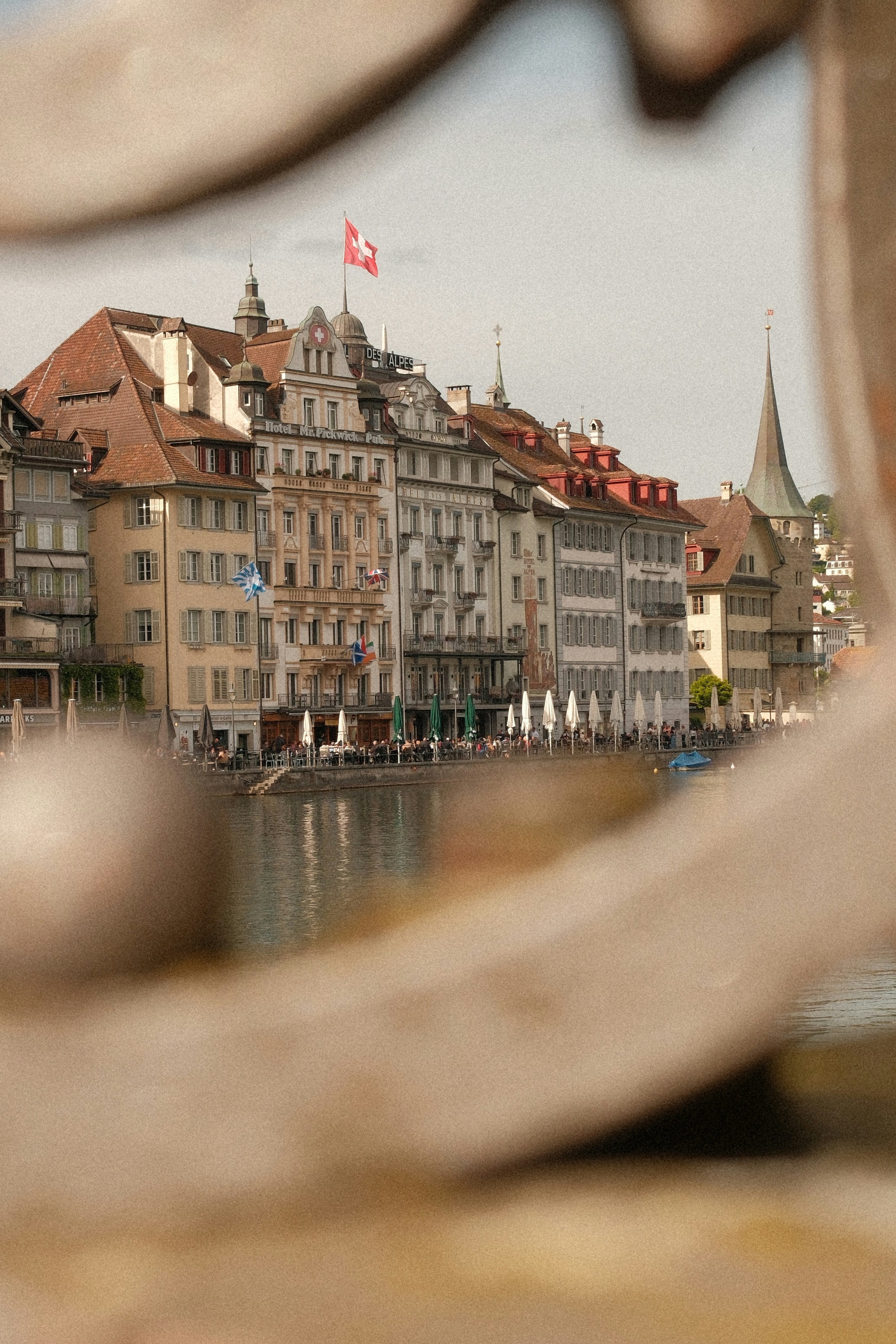 Ornate frame highlights historic swiss buildings beside calm water.