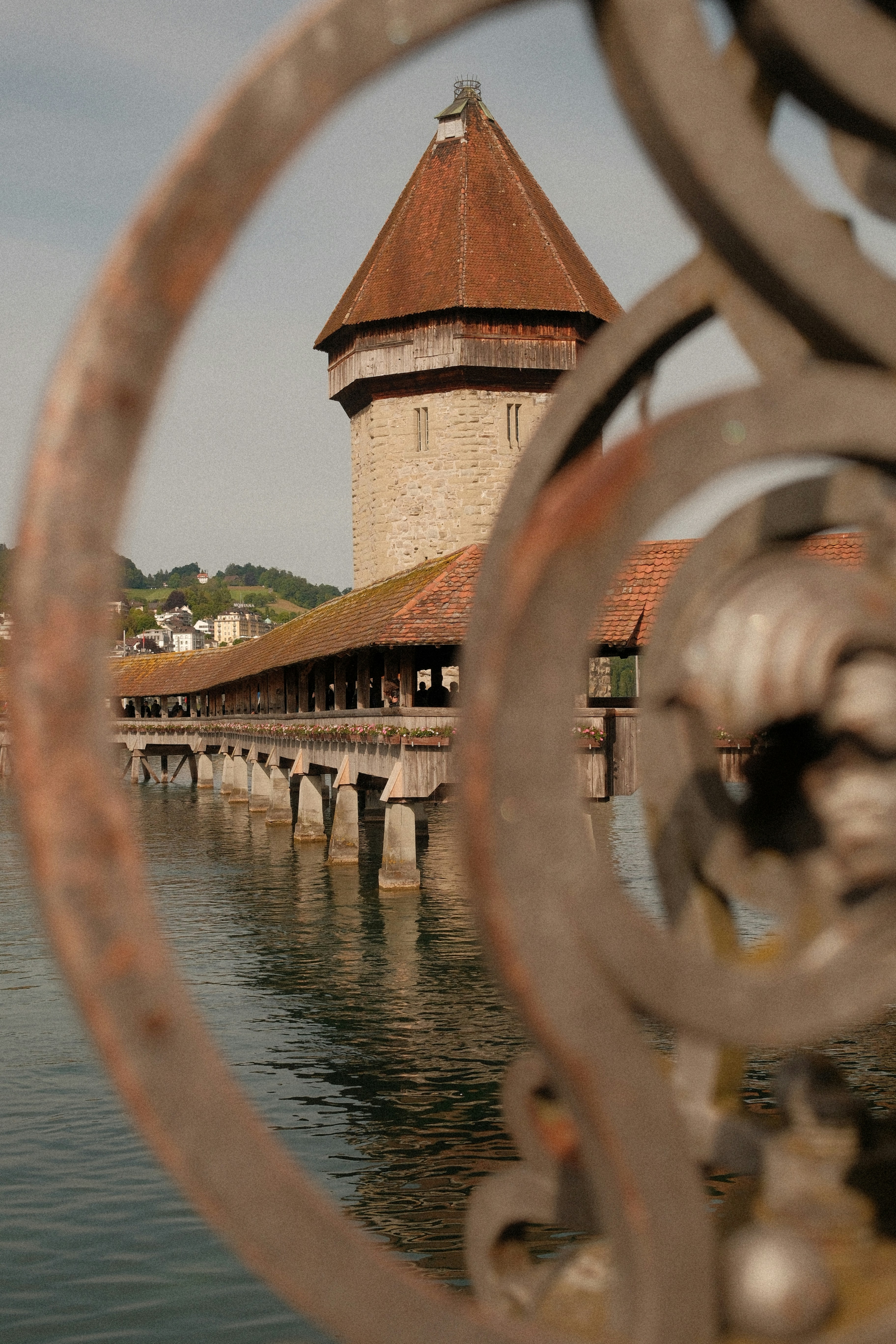 Castle Tower Framed by Ornate Ironwork Over a Reflective River