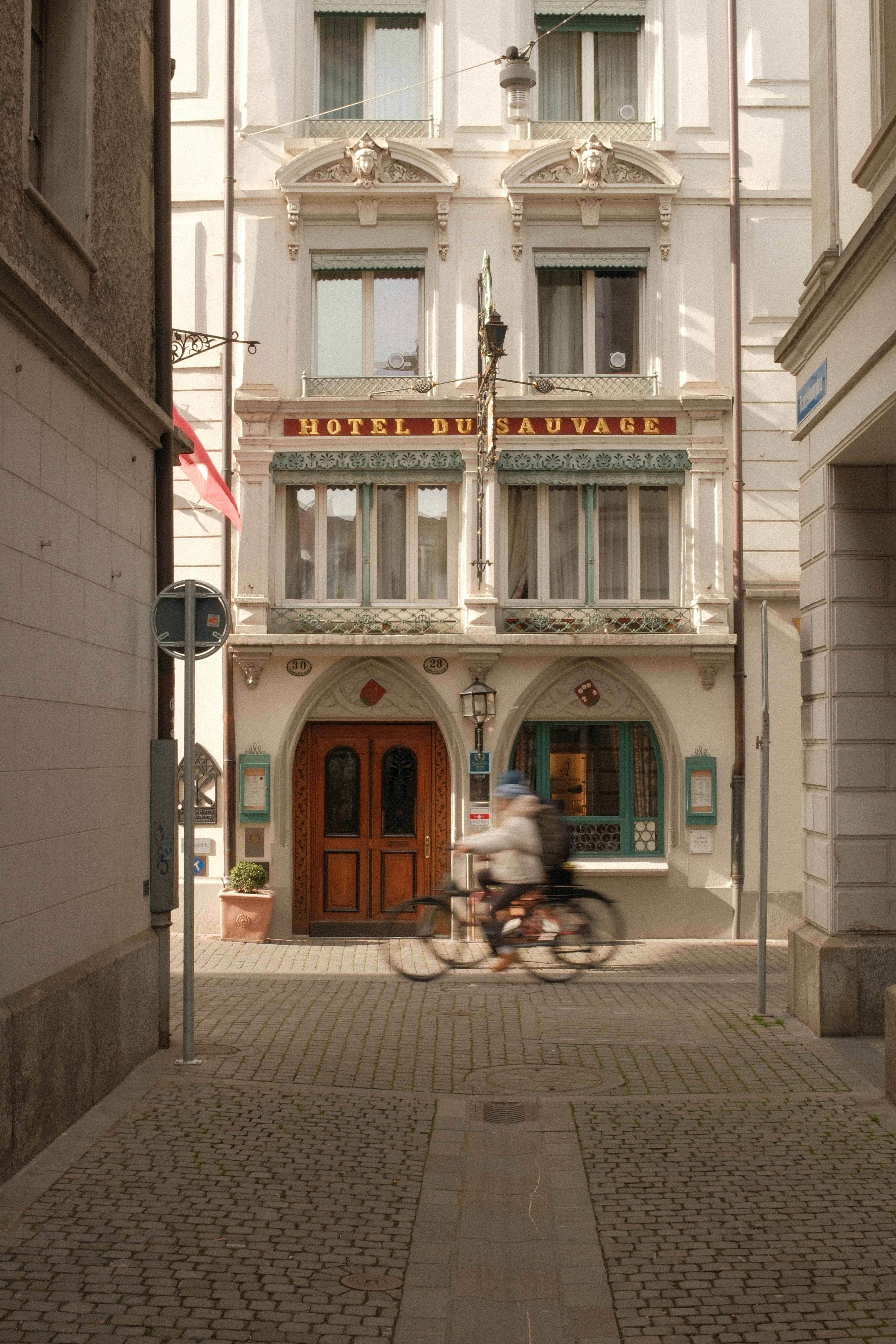 Cyclist in Motion Before the Hotel du Sauvage