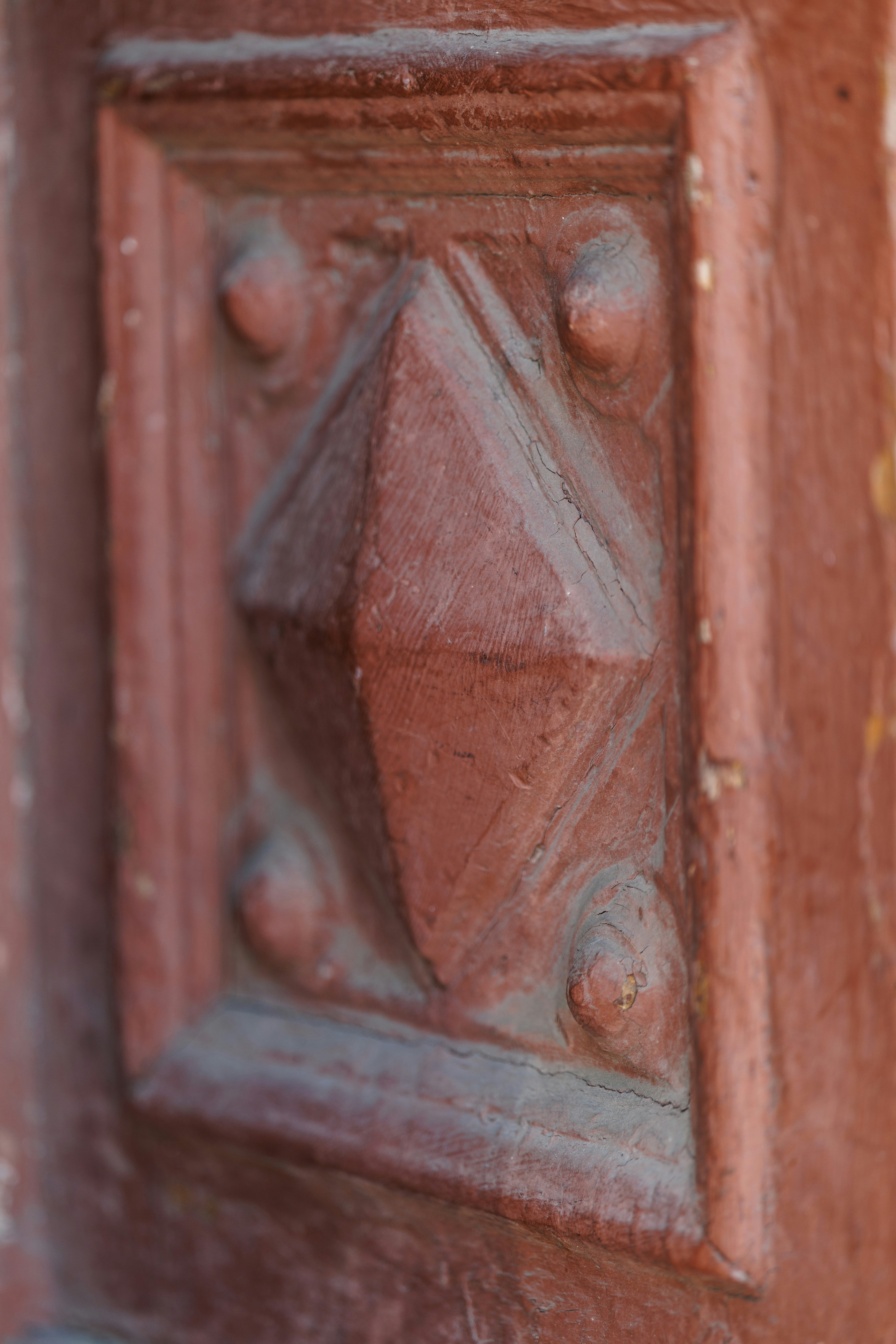 Close-Up of a Weathered Red Wooden Ornament