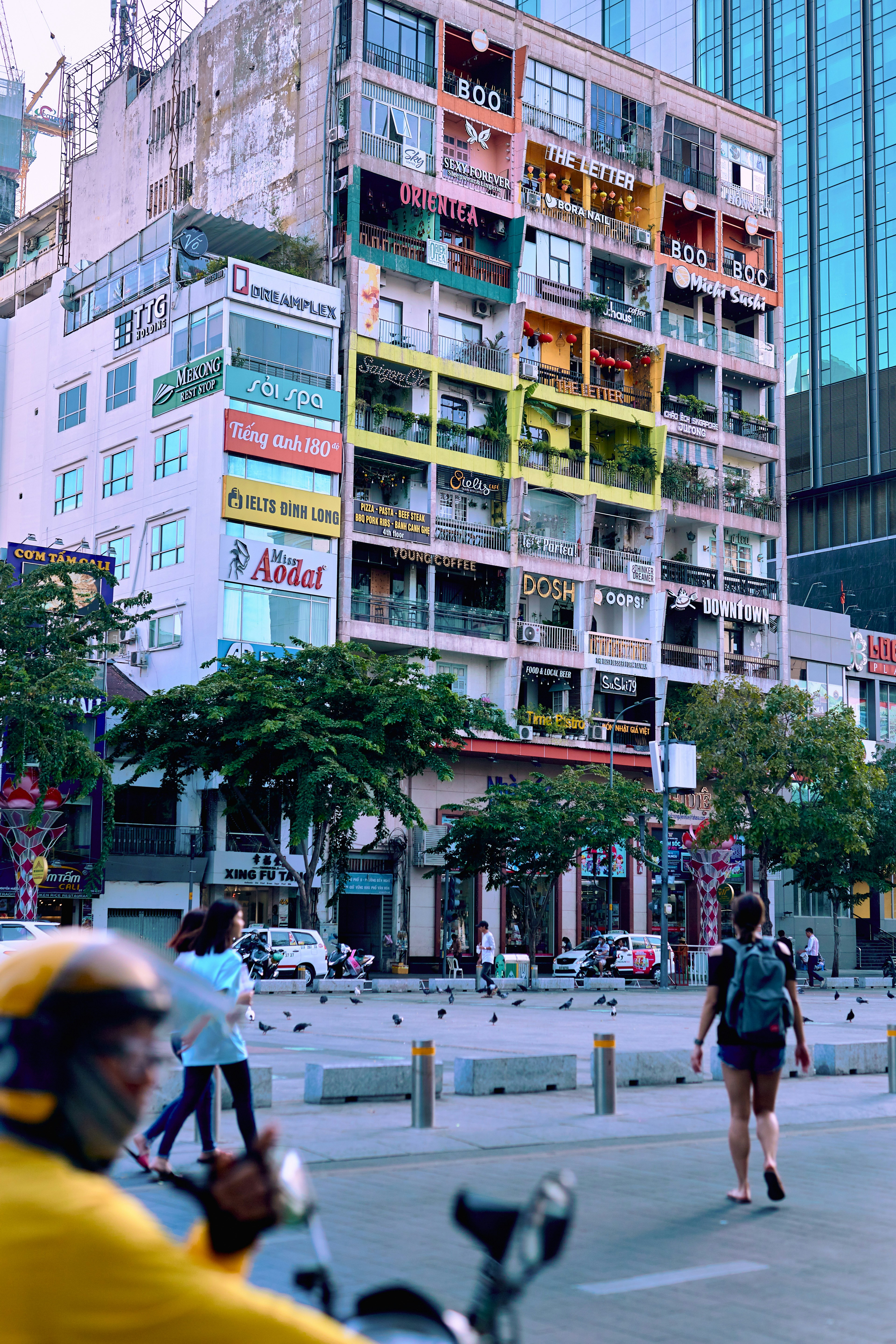 Colorful urban facade crowned with signs and pedestrians in motion