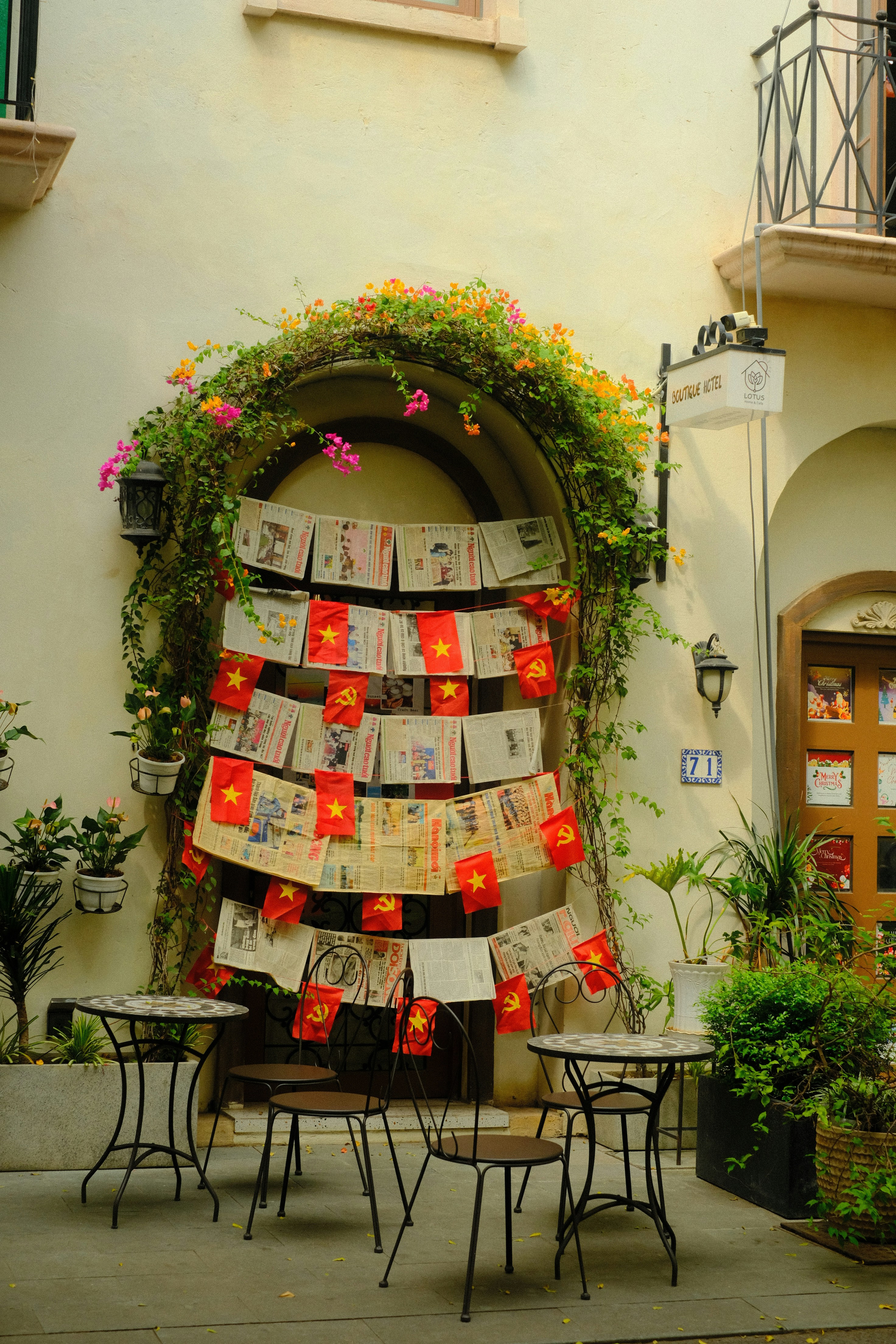 Archway of News: A Balcony of Flags Framing a Garden Café