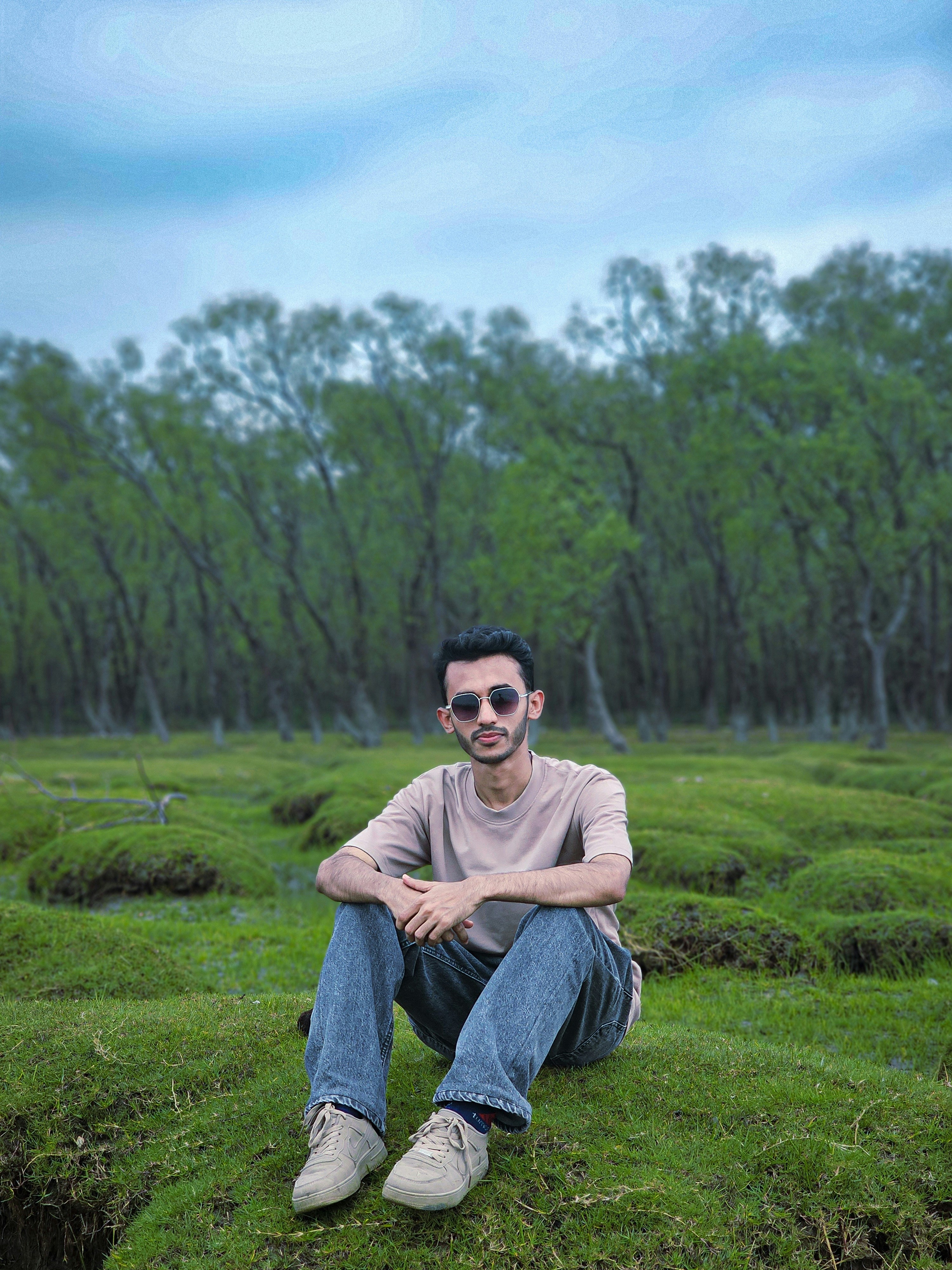 Sitting in a Green Whisper: A Man Among Quiet Mnarshy Tufts