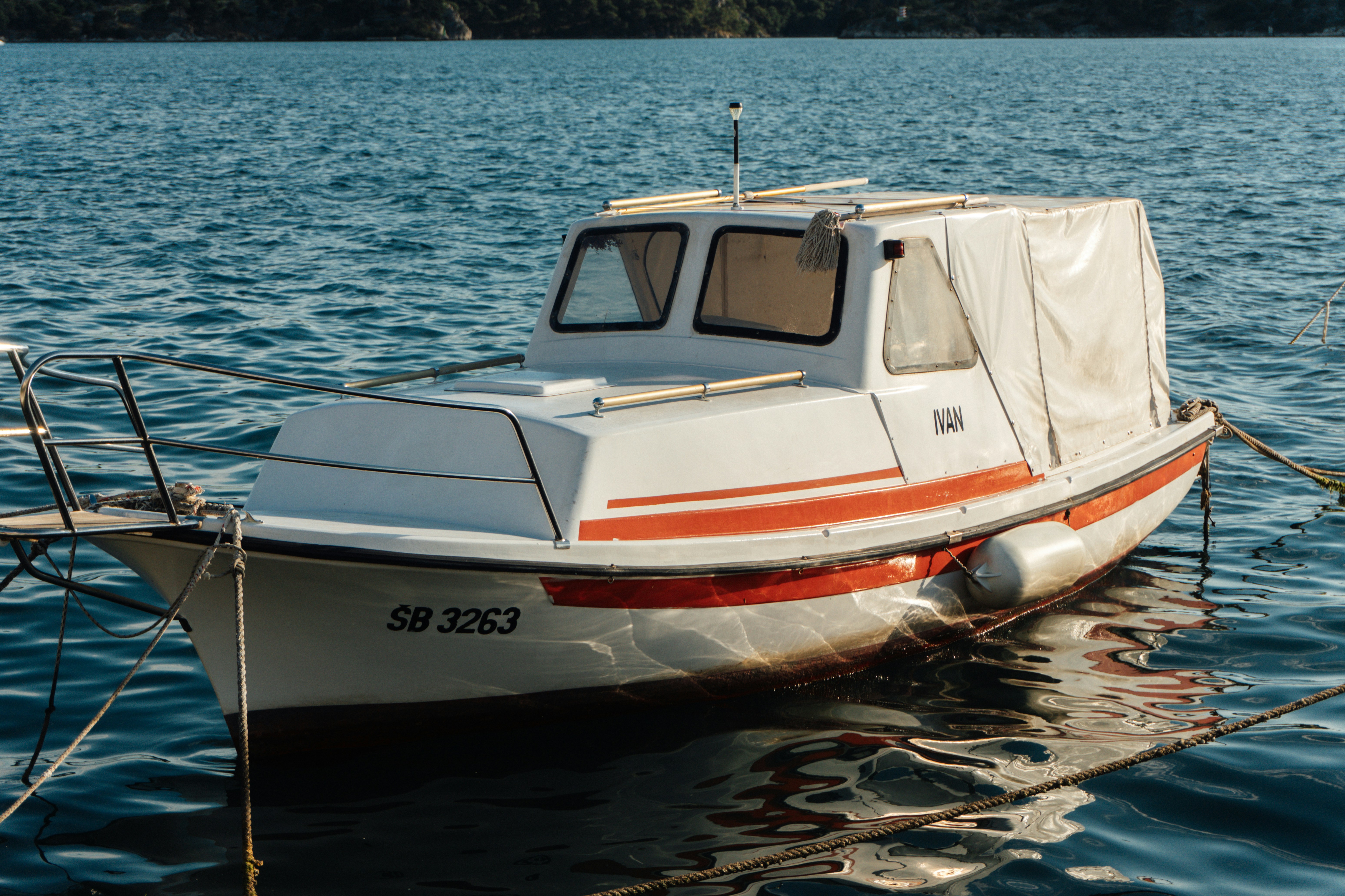 White cabin cruiser moored in tranquil blue harbor