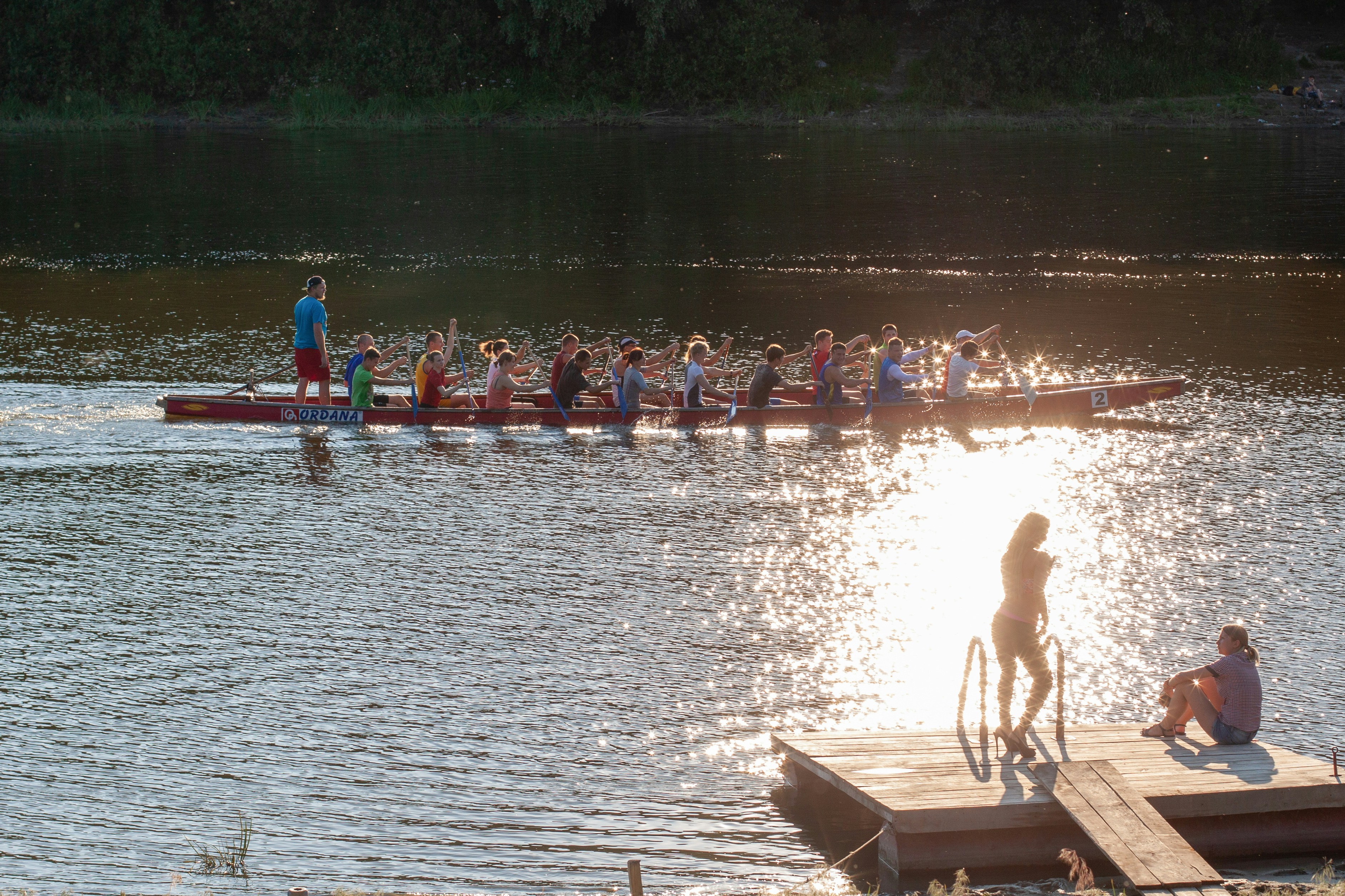 Sunlit Dragon Boat: Rowers in a River Ribbon