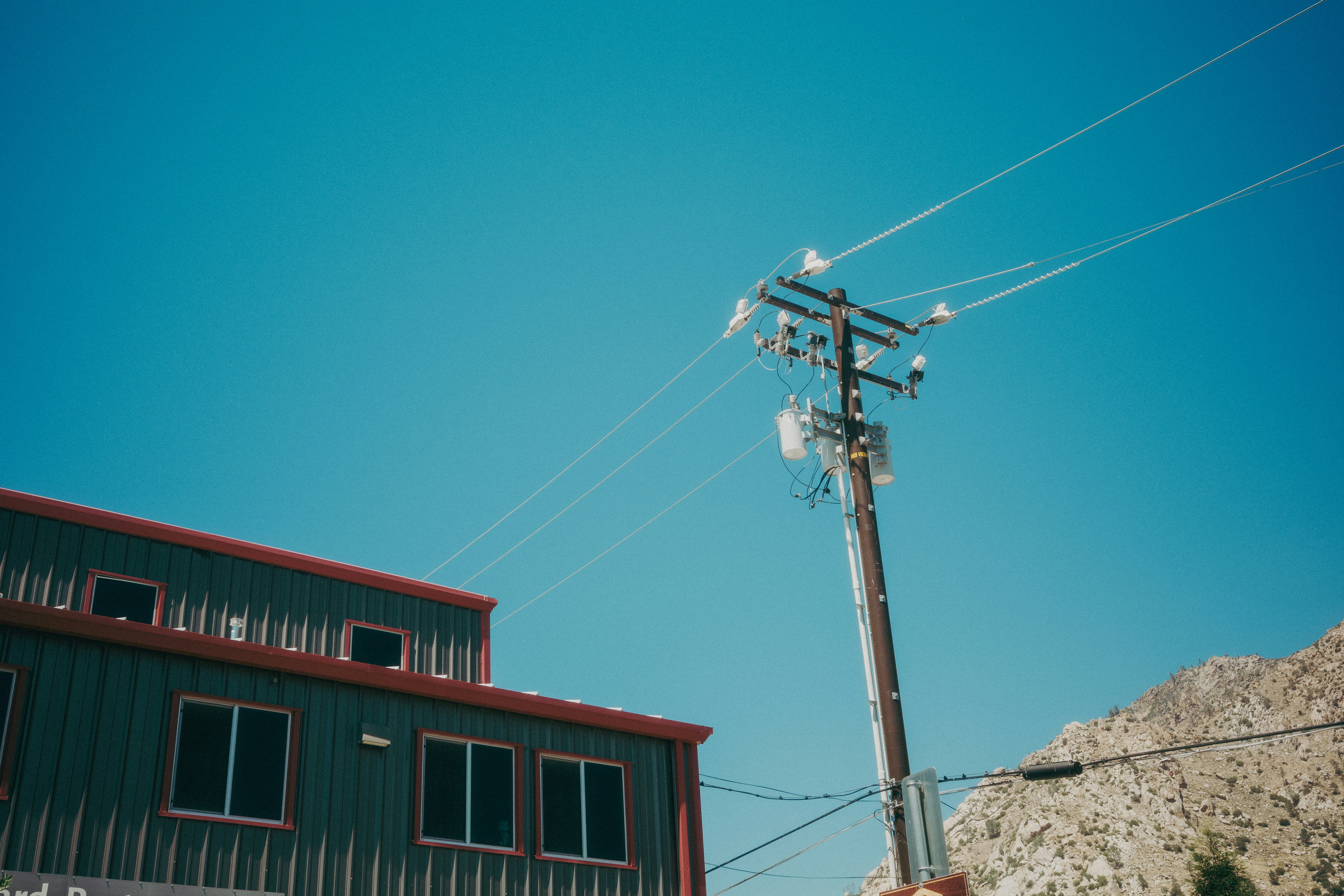 Power Lines Against a Desert Sky Hover Over a Faceted Building