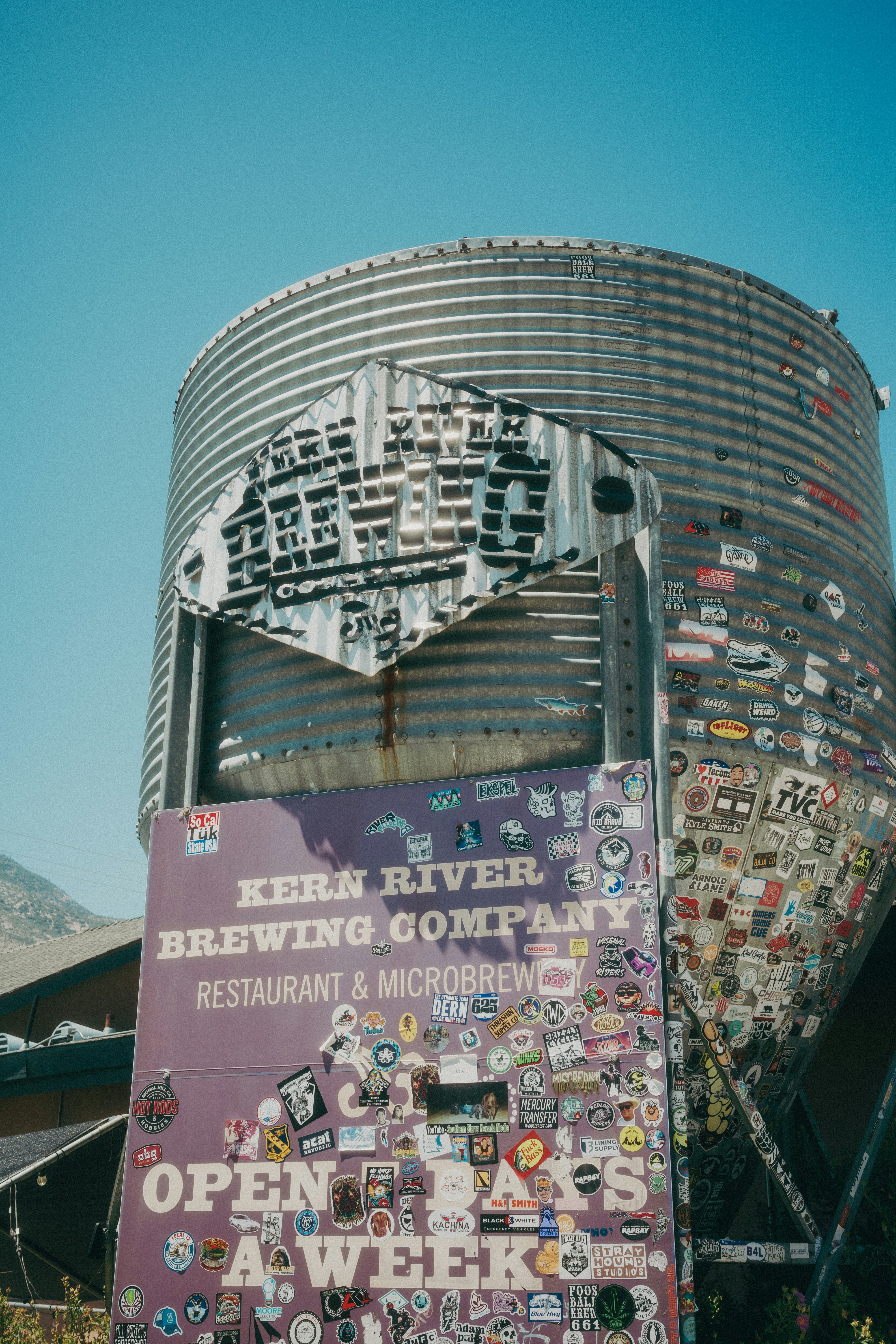 Stickered Silo: A Purple Signage Across Corrugated Steel