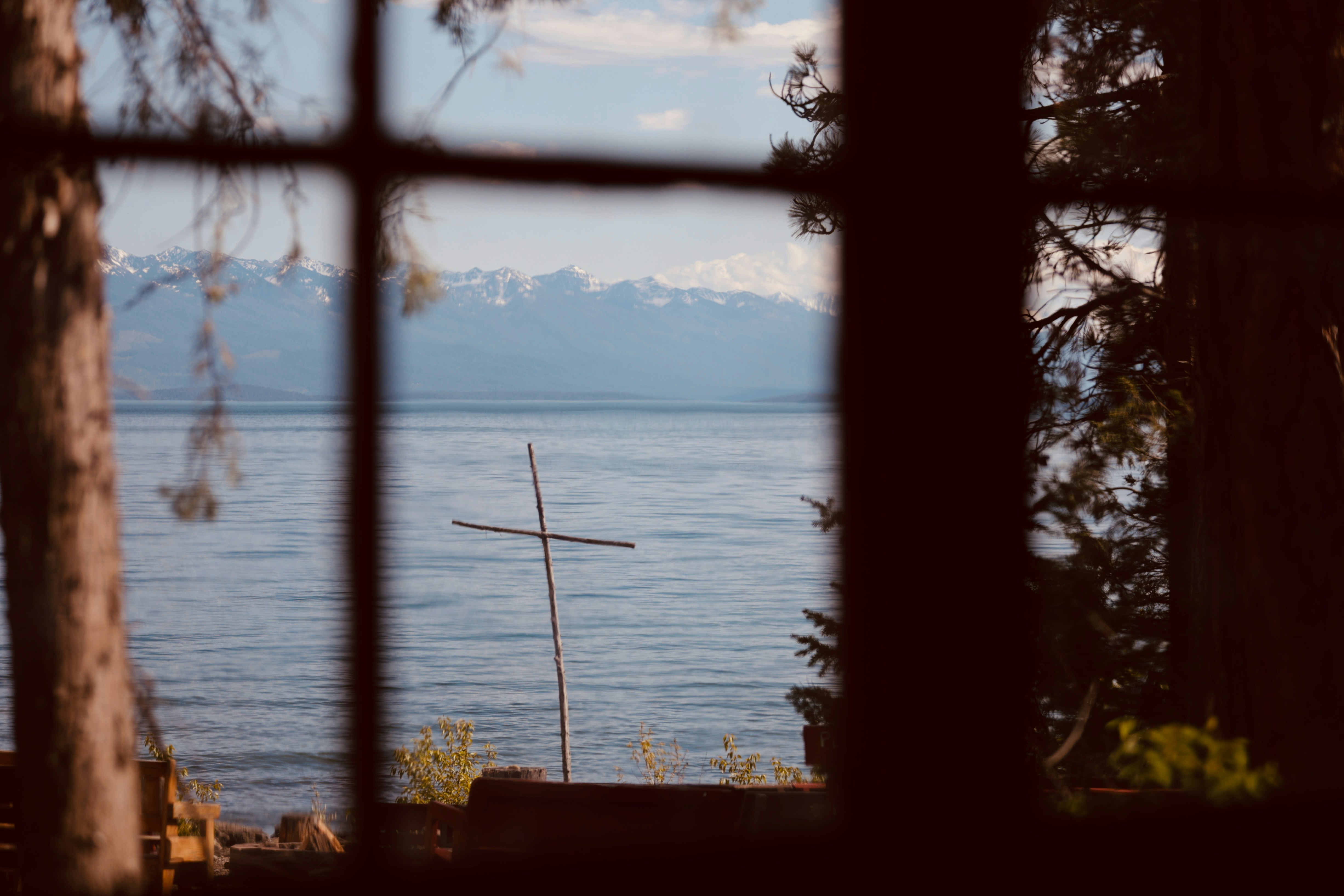 Coastal crosshair: a lone cross by the tranquil bay