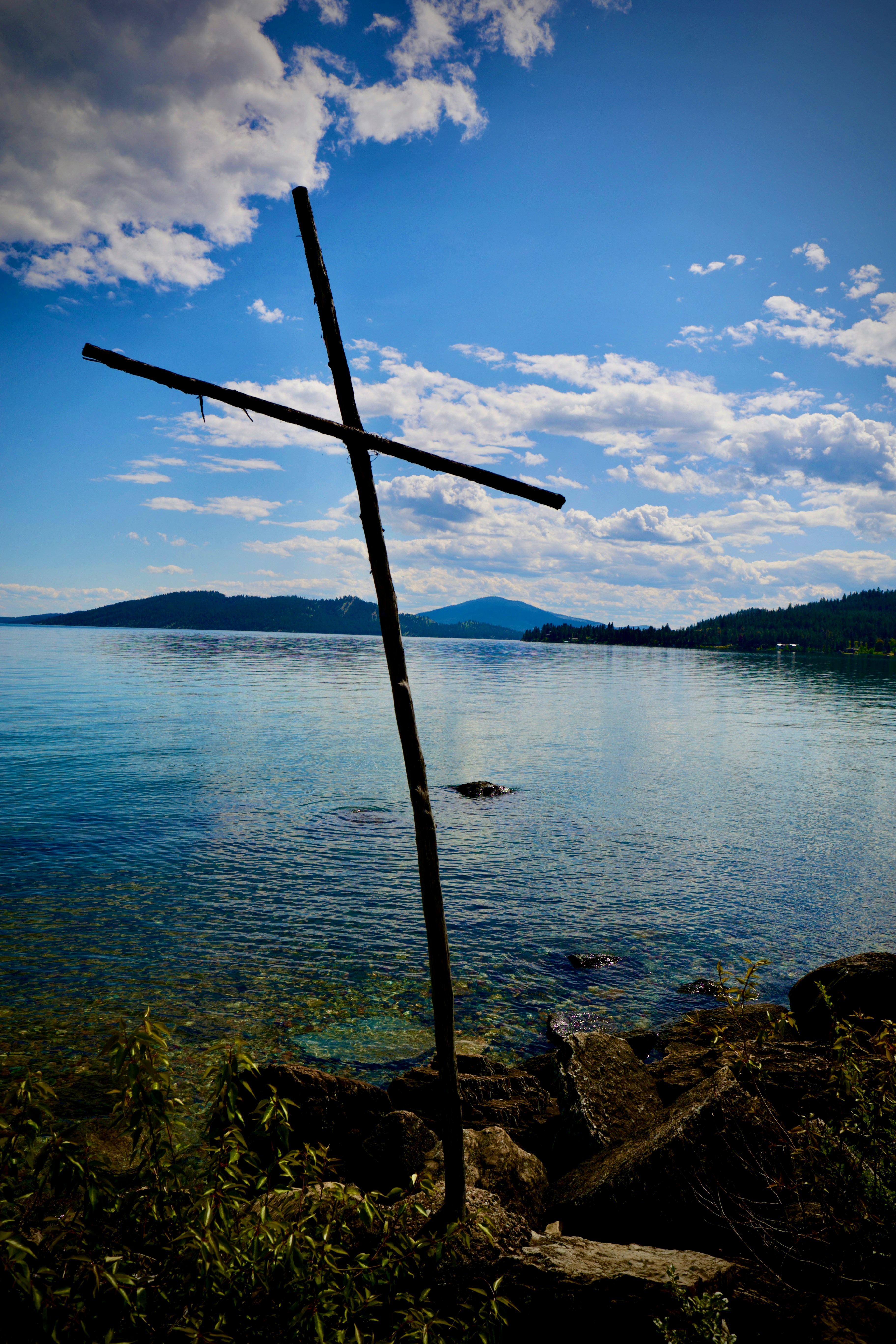 Beacon on the Bay: A Weathered Cross Framing a Calm Inland